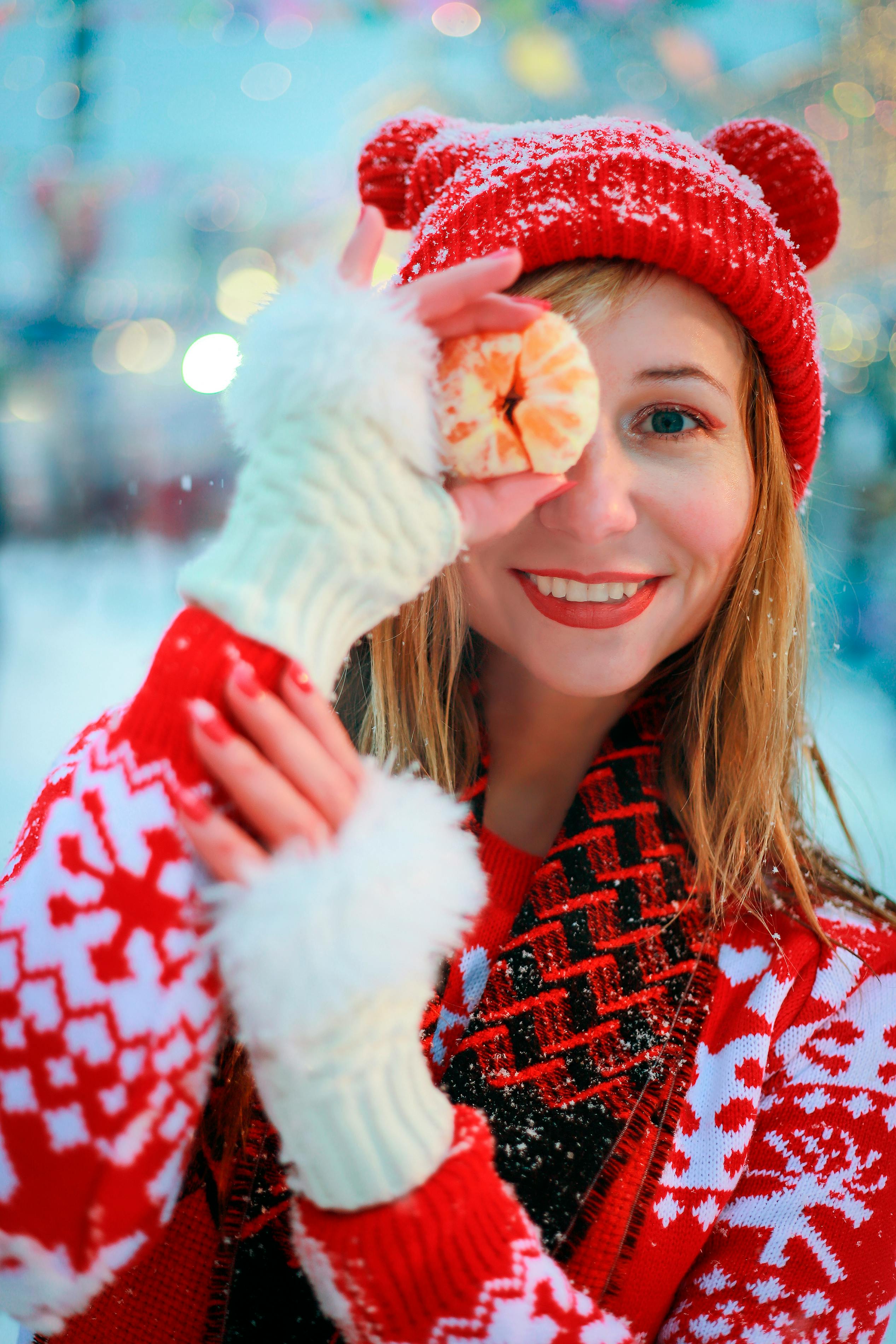 Smiling Woman in Red Sweater Posing with Clementine in Hand · Free ...