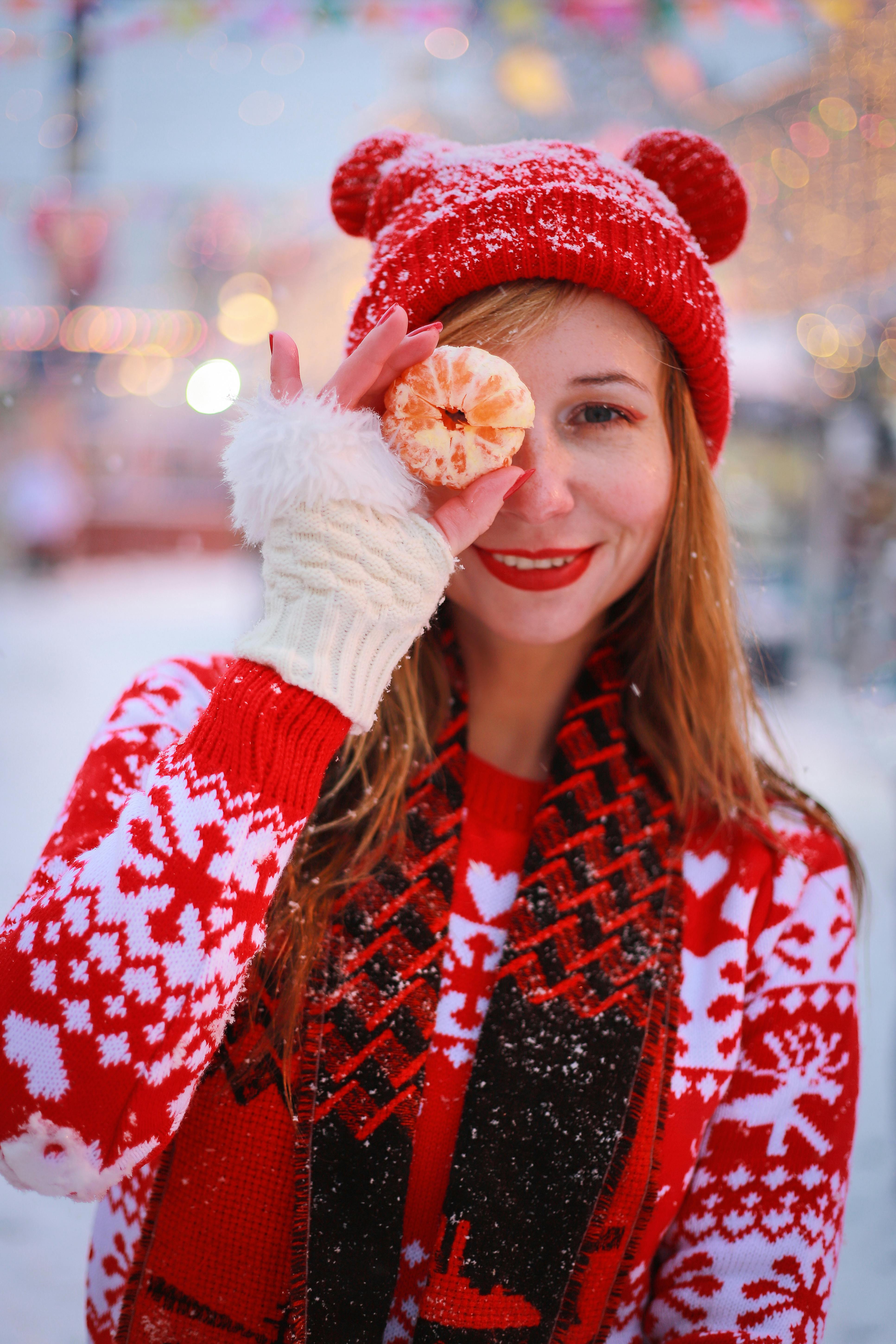 Woman Holding a Tangerine by her Face · Free Stock Photo