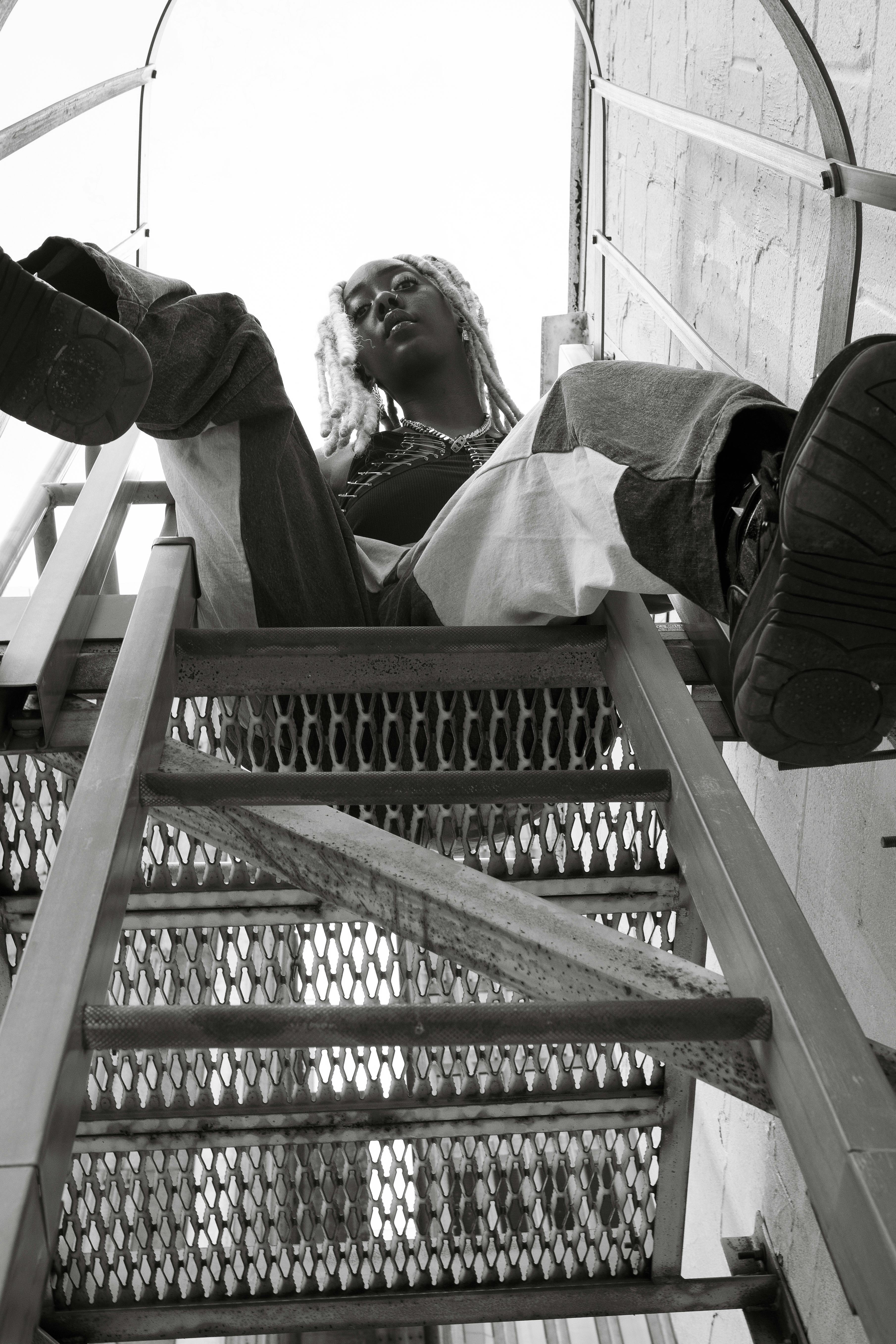 Fashion model posing ontop of a metal staircase · Free Stock Photo