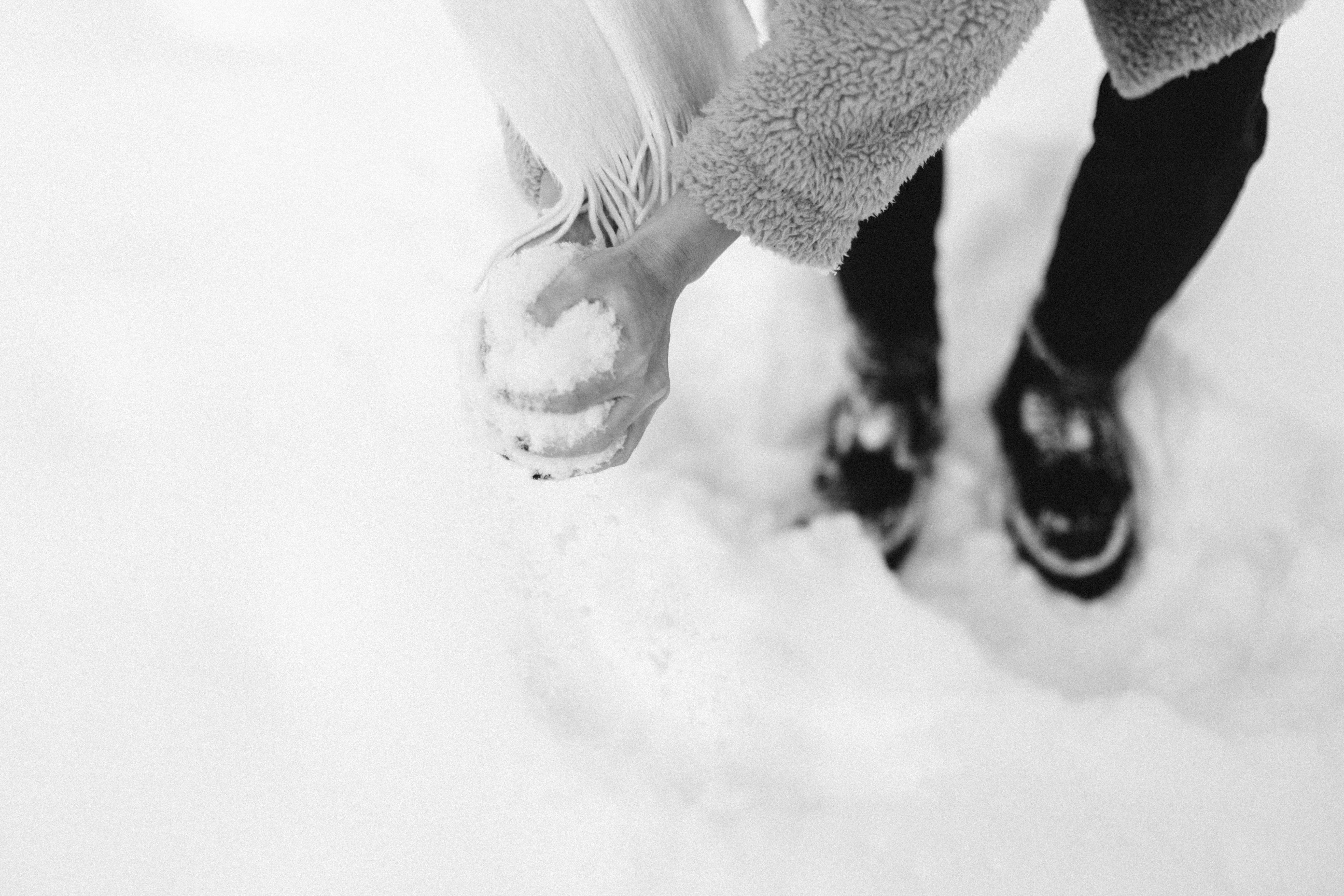 A black and white photo of a person holding a snow ball · Free Stock Photo