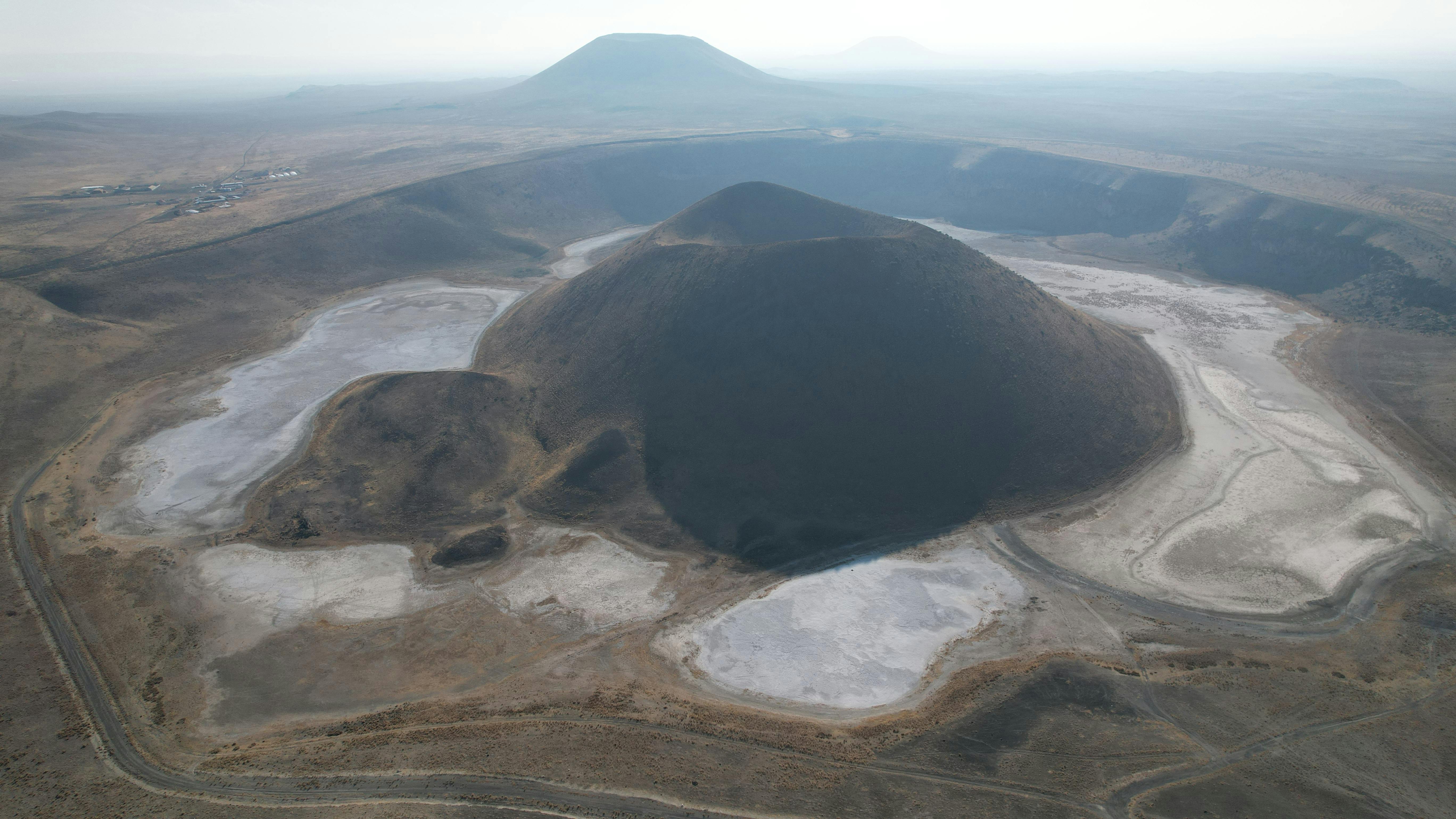 A Volcano with Smoke Beside a Green Mountain · Free Stock Photo
