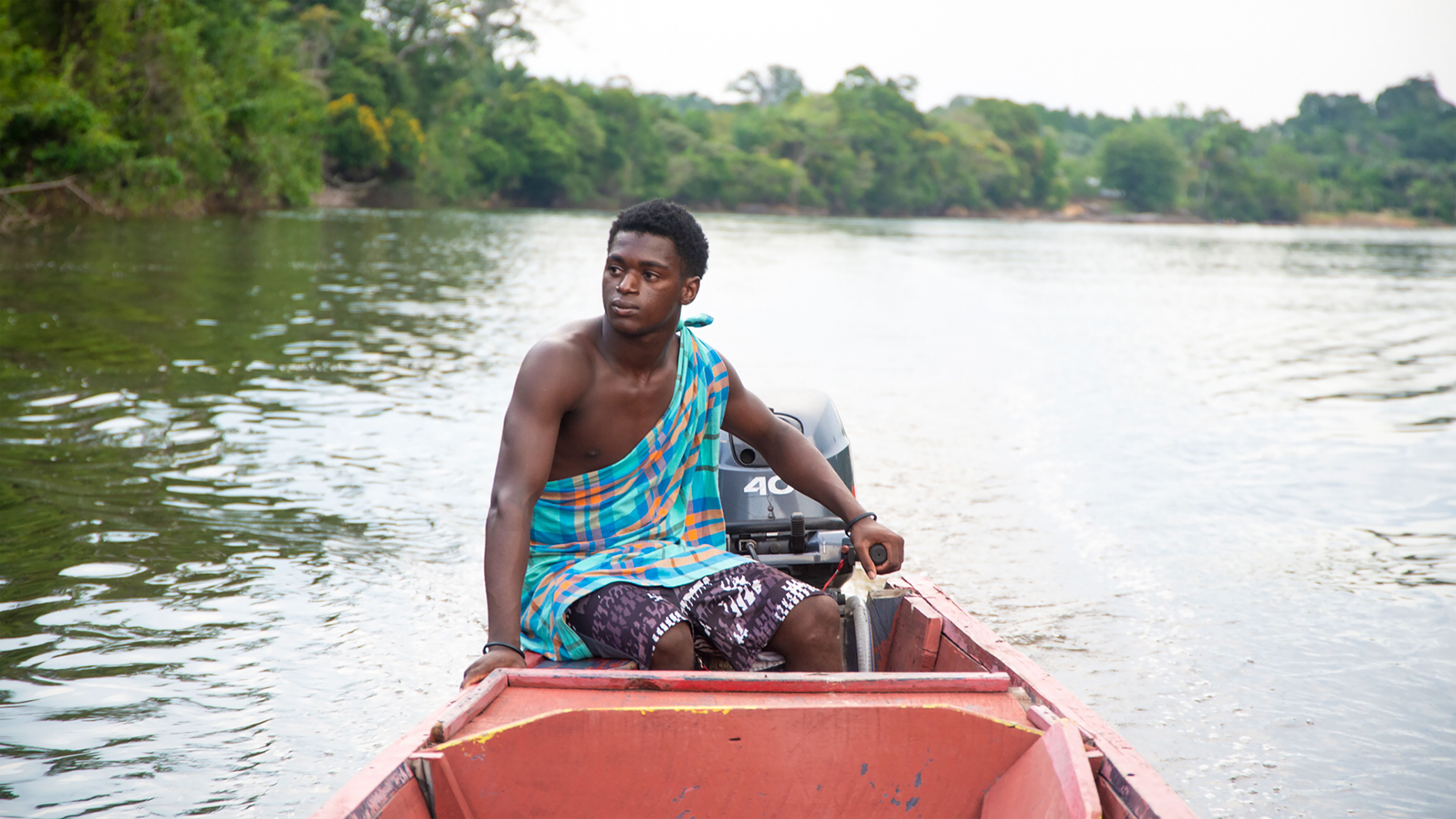 Young Man Sailing along a River in a Motorboat · Free Stock Photo
