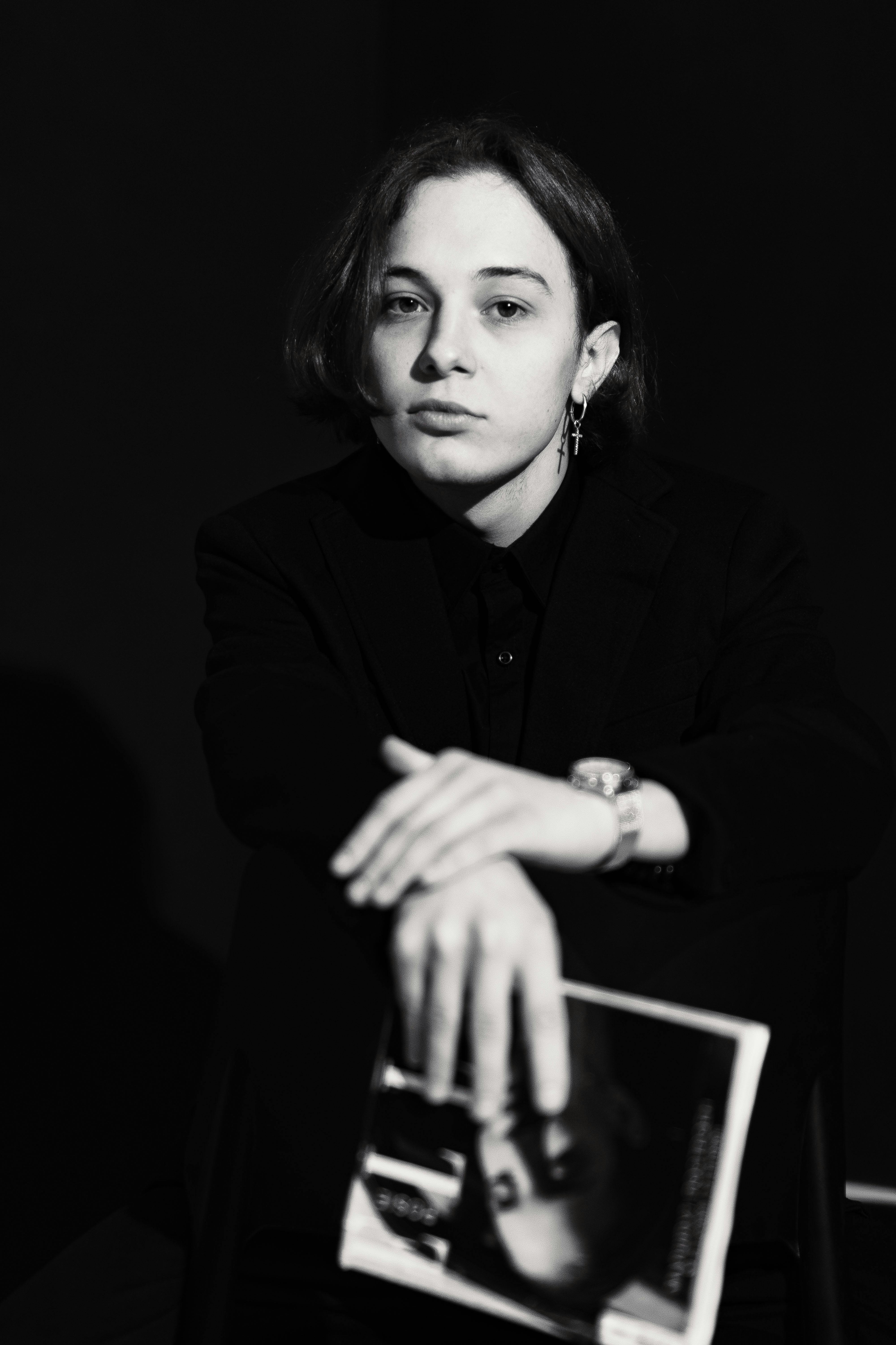 Black and White Photo of a Young Person in an Elegant Outfit Holding a ...