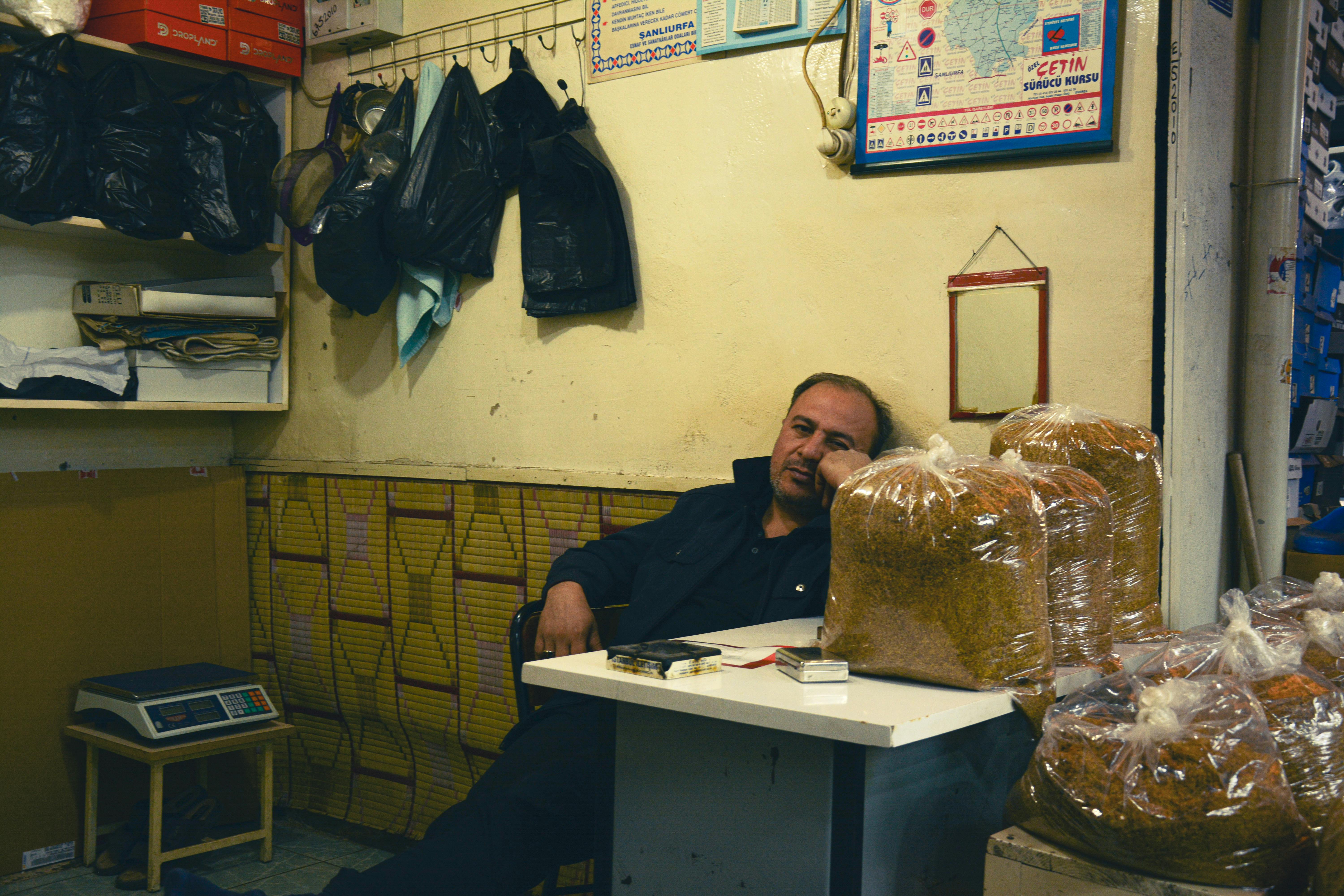 Shopkeeper resting in a cozy corner store · Free Stock Photo