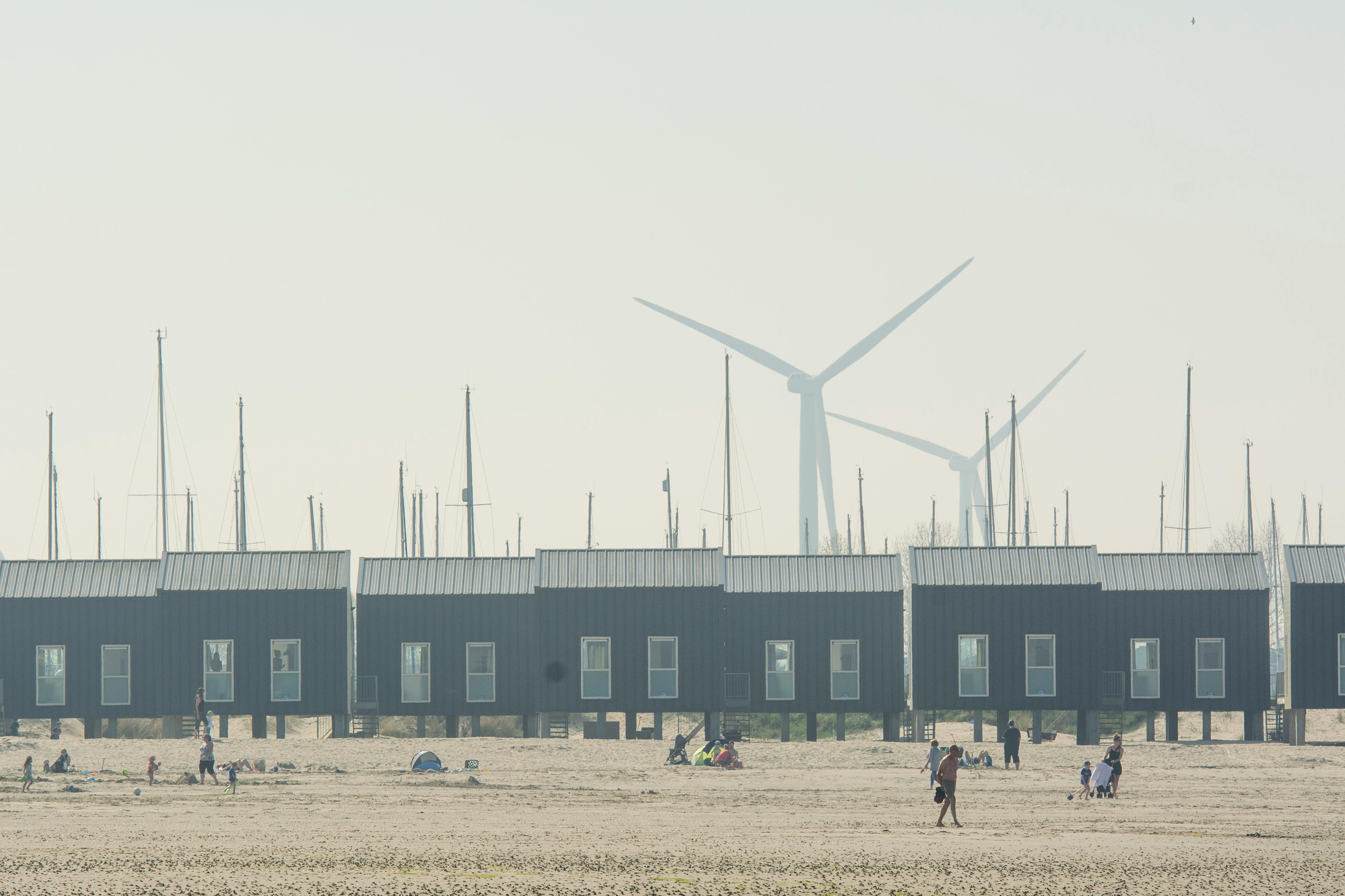 Wind Turbines behind Huts on Beach · Free Stock Photo