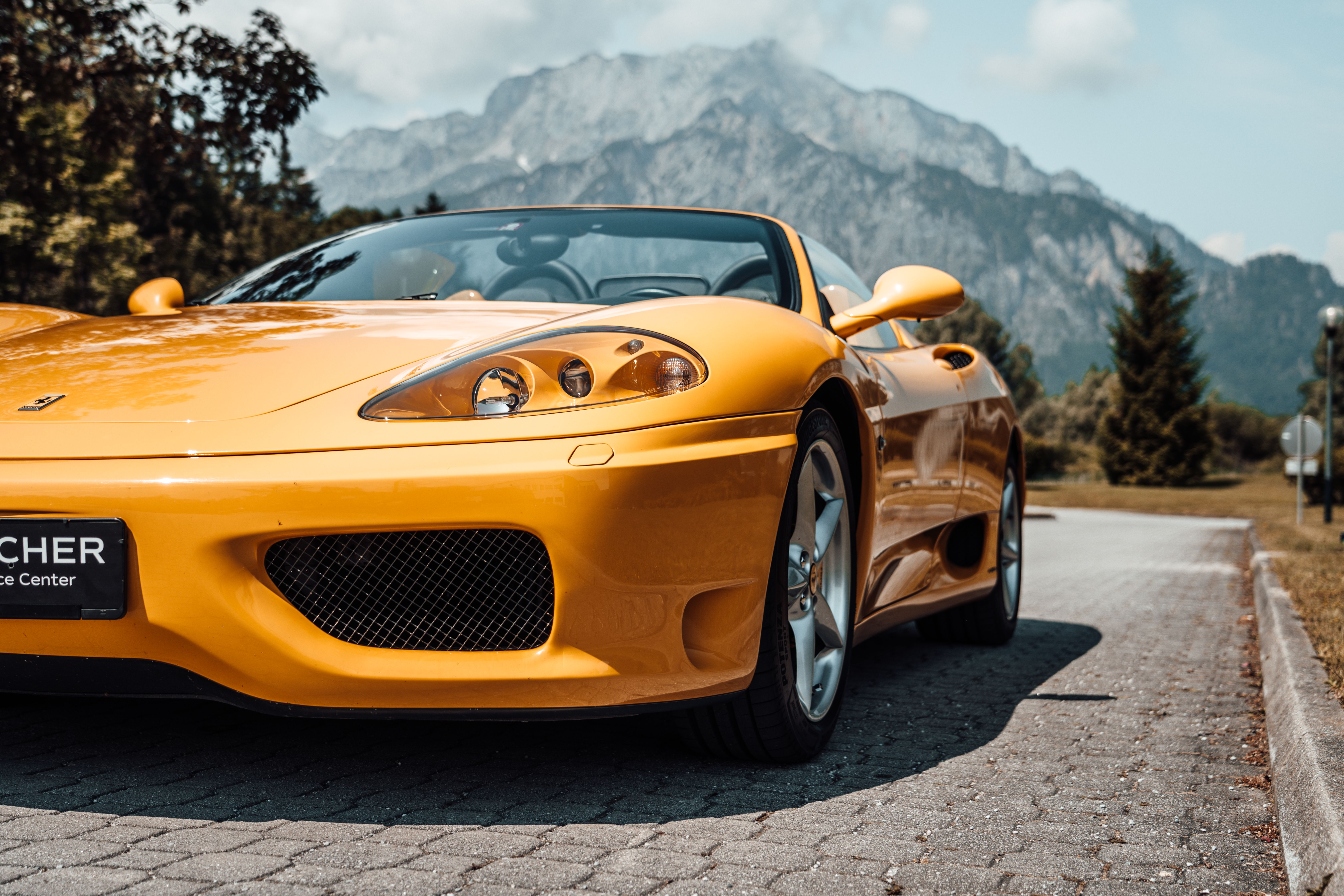 Closeup of a Yellow Sports Car in a Mountain Landscape · Free Stock Photo