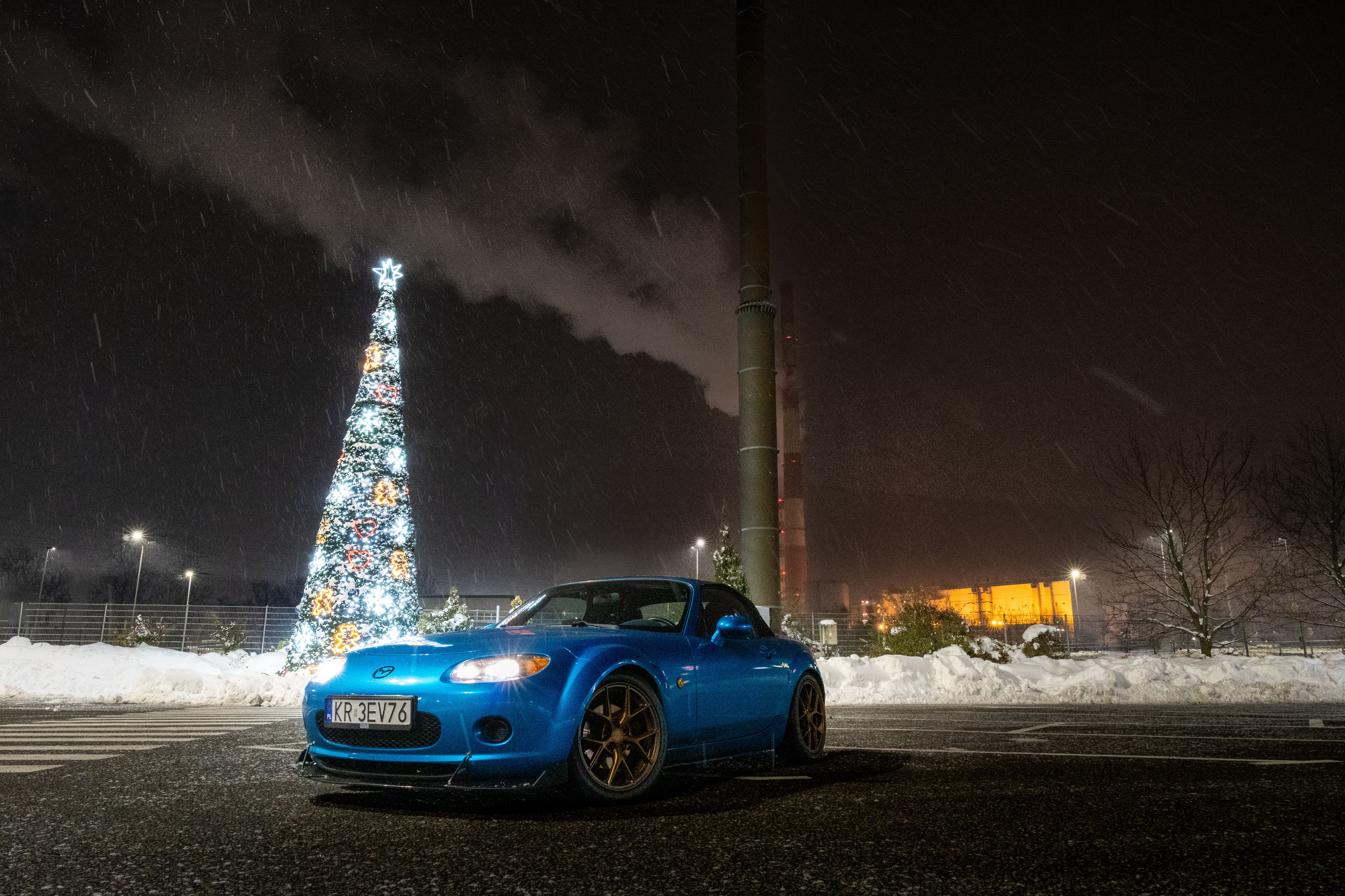 A Blue Mazda MX-5 Parked near an Illuminated Christmas Tree in a City ...
