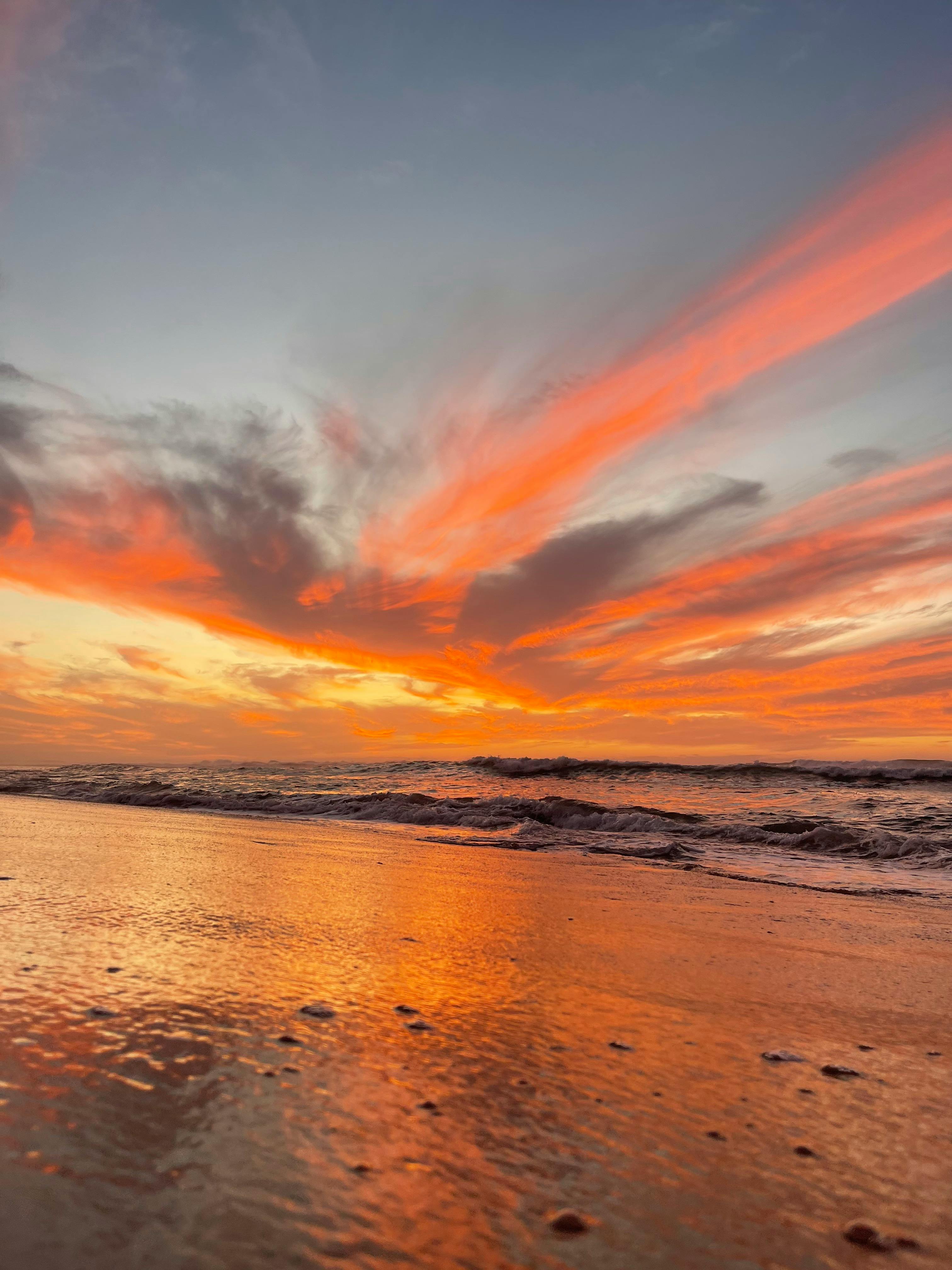 Dramatic Sunset Cloudscape Reflecting on Wet Beach Sand · Free Stock Photo