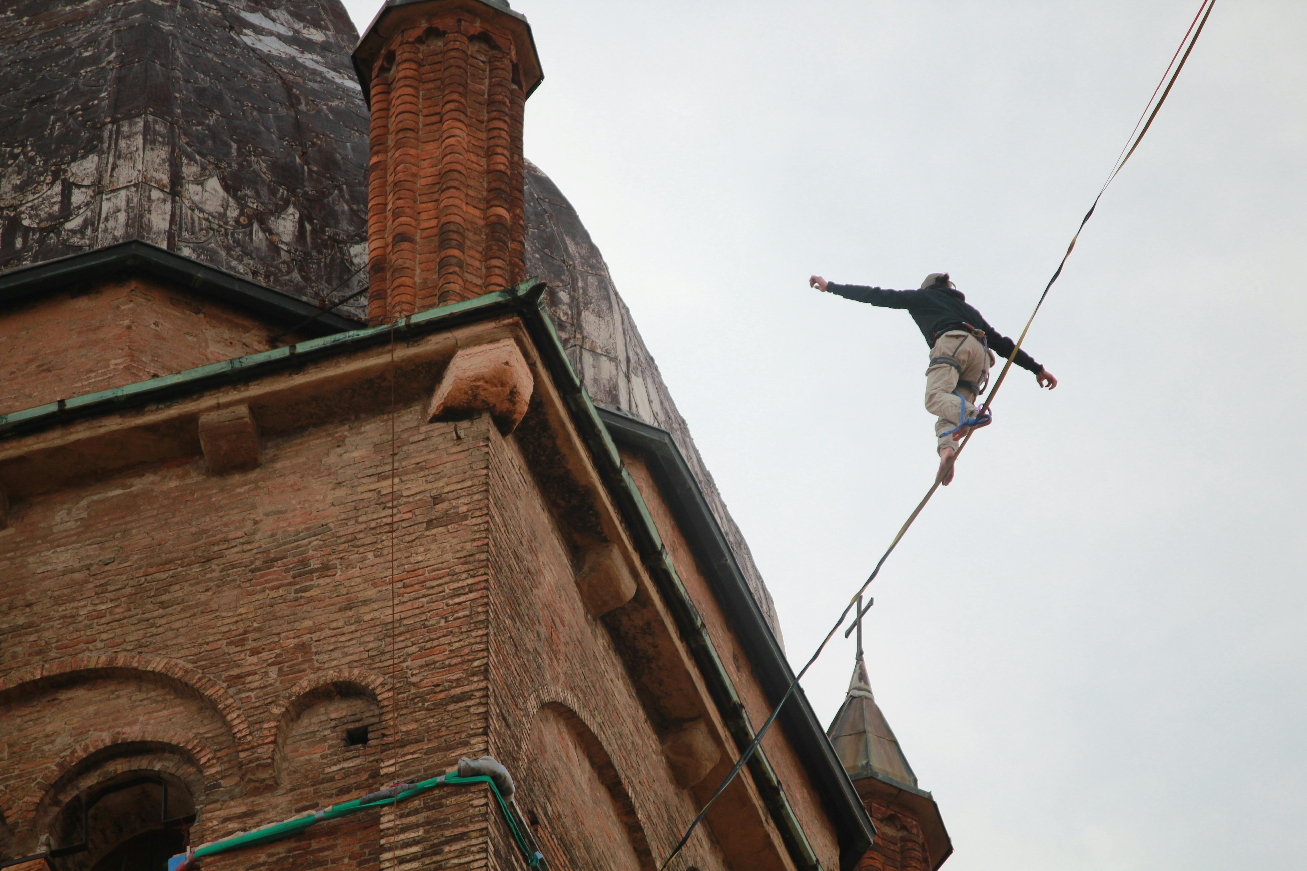 Acrobat Walking on Line on Church · Free Stock Photo