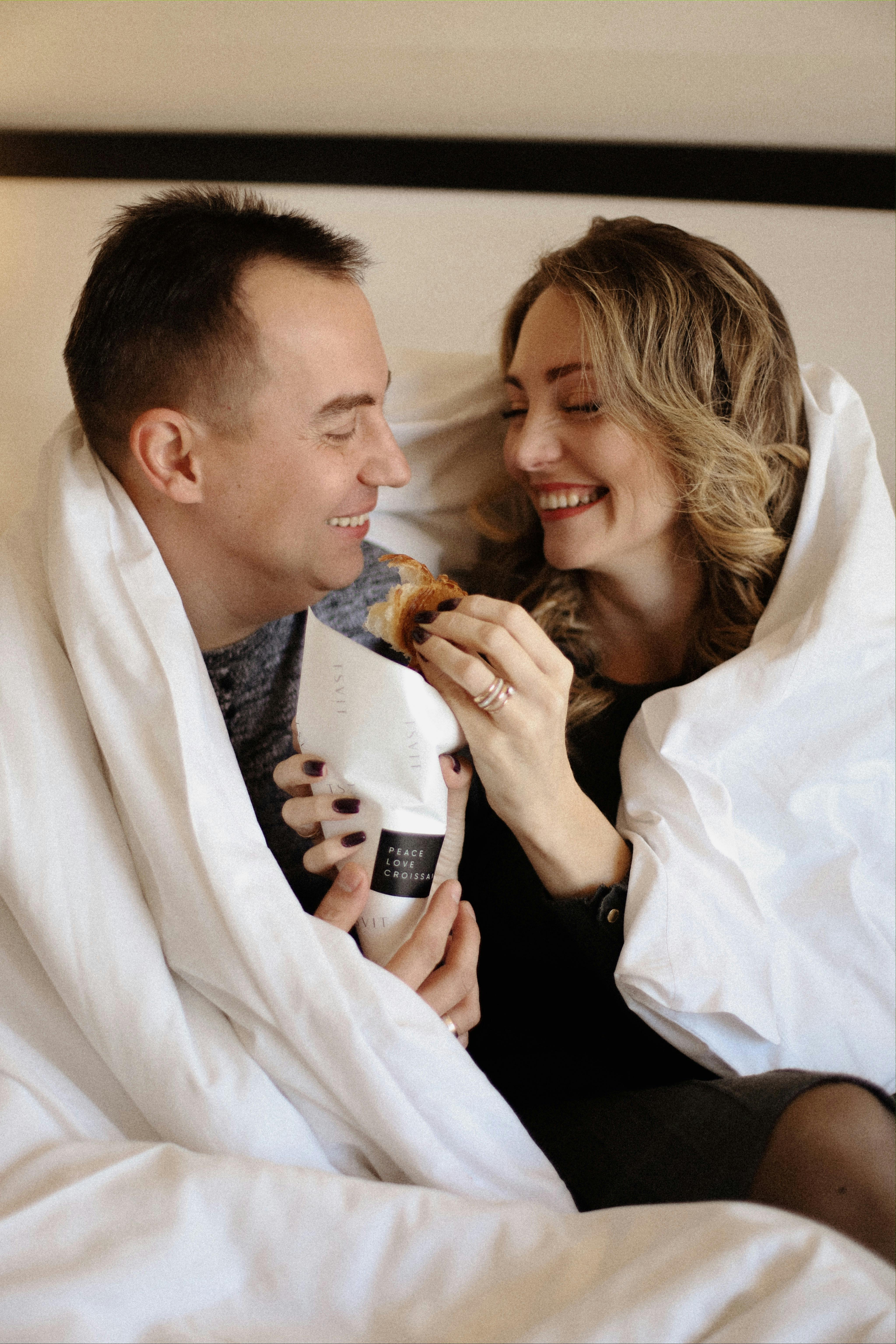 Happy Couple Snacking in Bed · Free Stock Photo