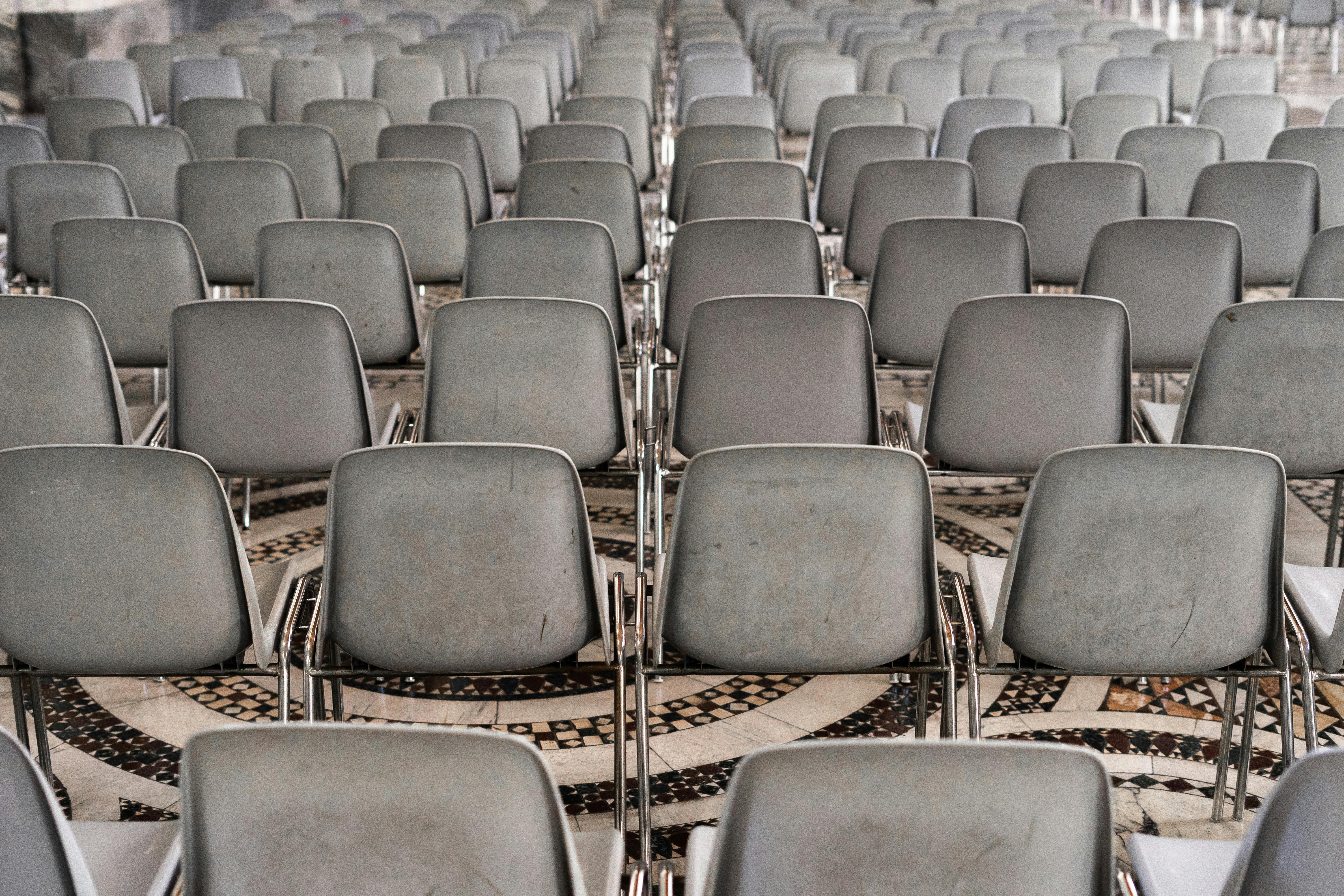 Empty chairs in a large room with a marble floor · Free Stock Photo