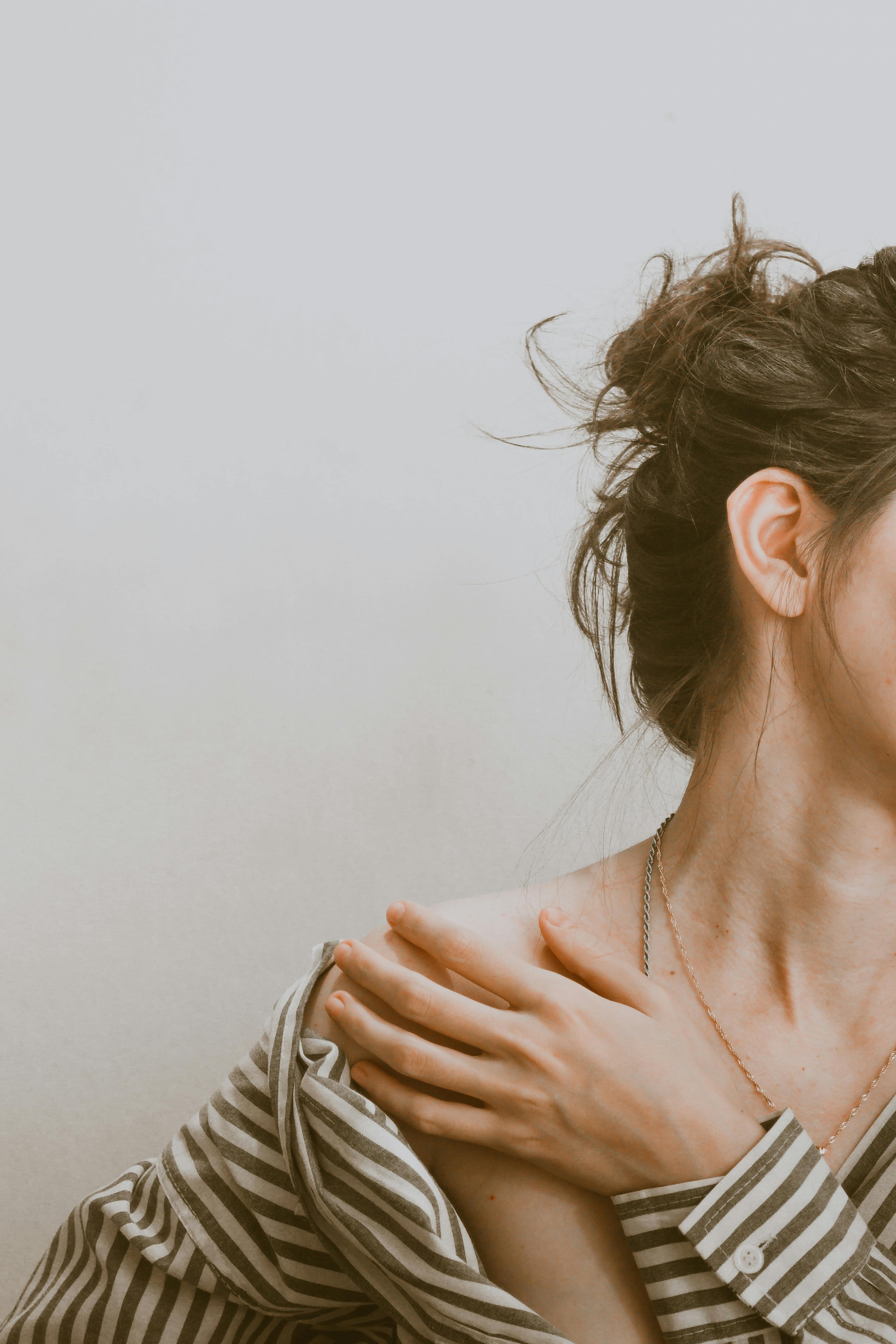 A Woman Touching her Shoulder · Free Stock Photo