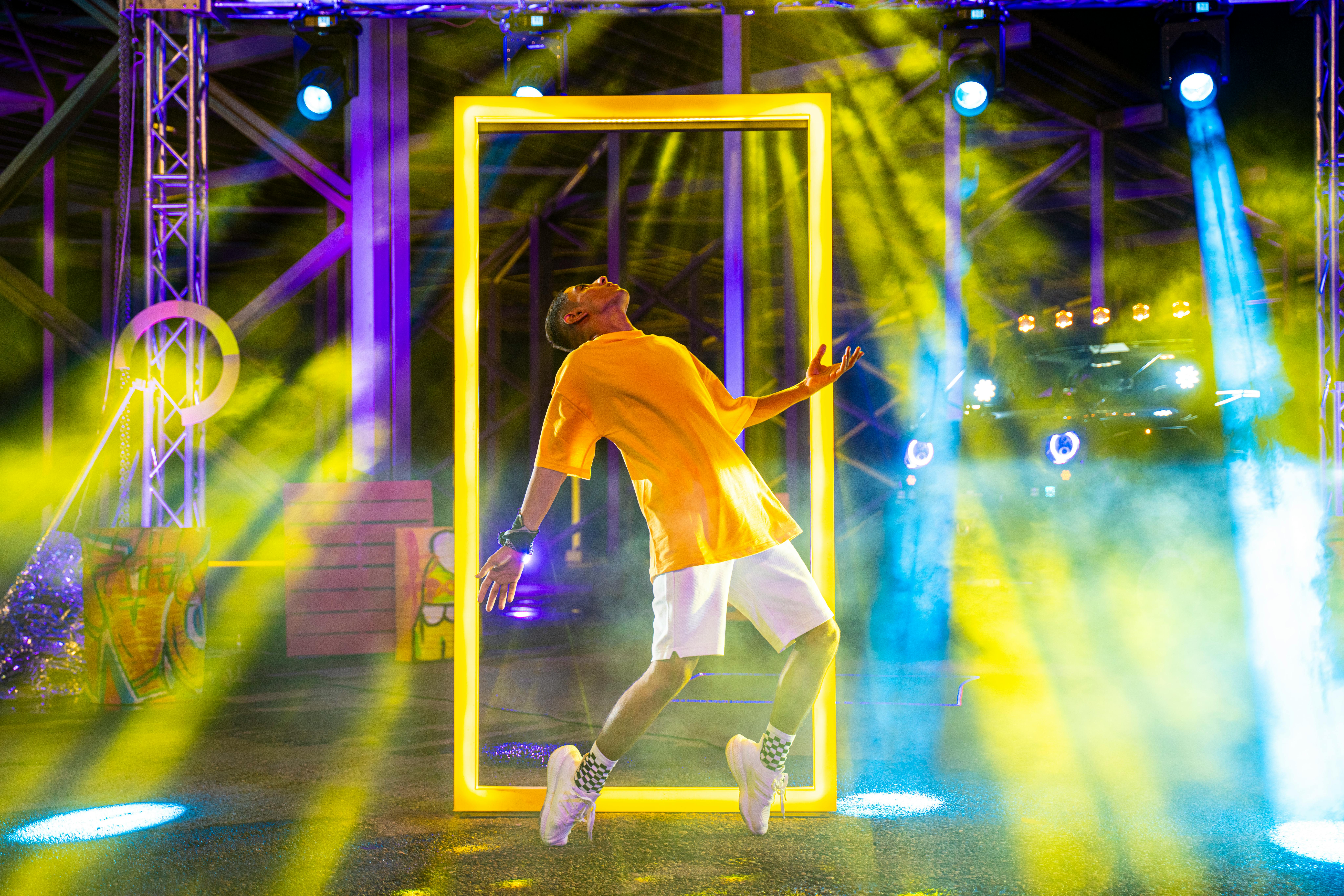 Man Performing on Stage in Colorful Lights and Smoke · Free Stock Photo