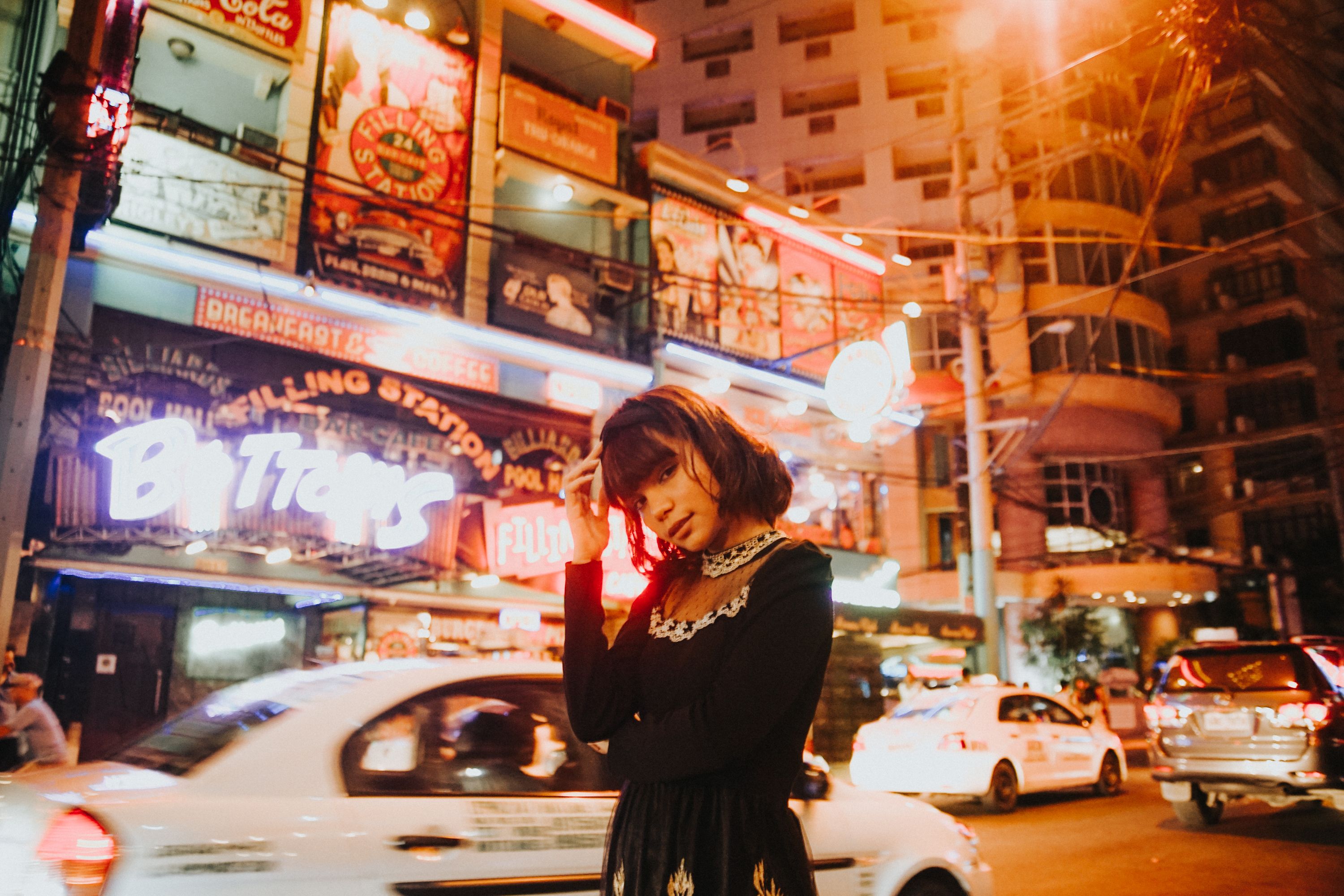 A Girl Standing on a Busy Illuminated Street in City · Free Stock Photo