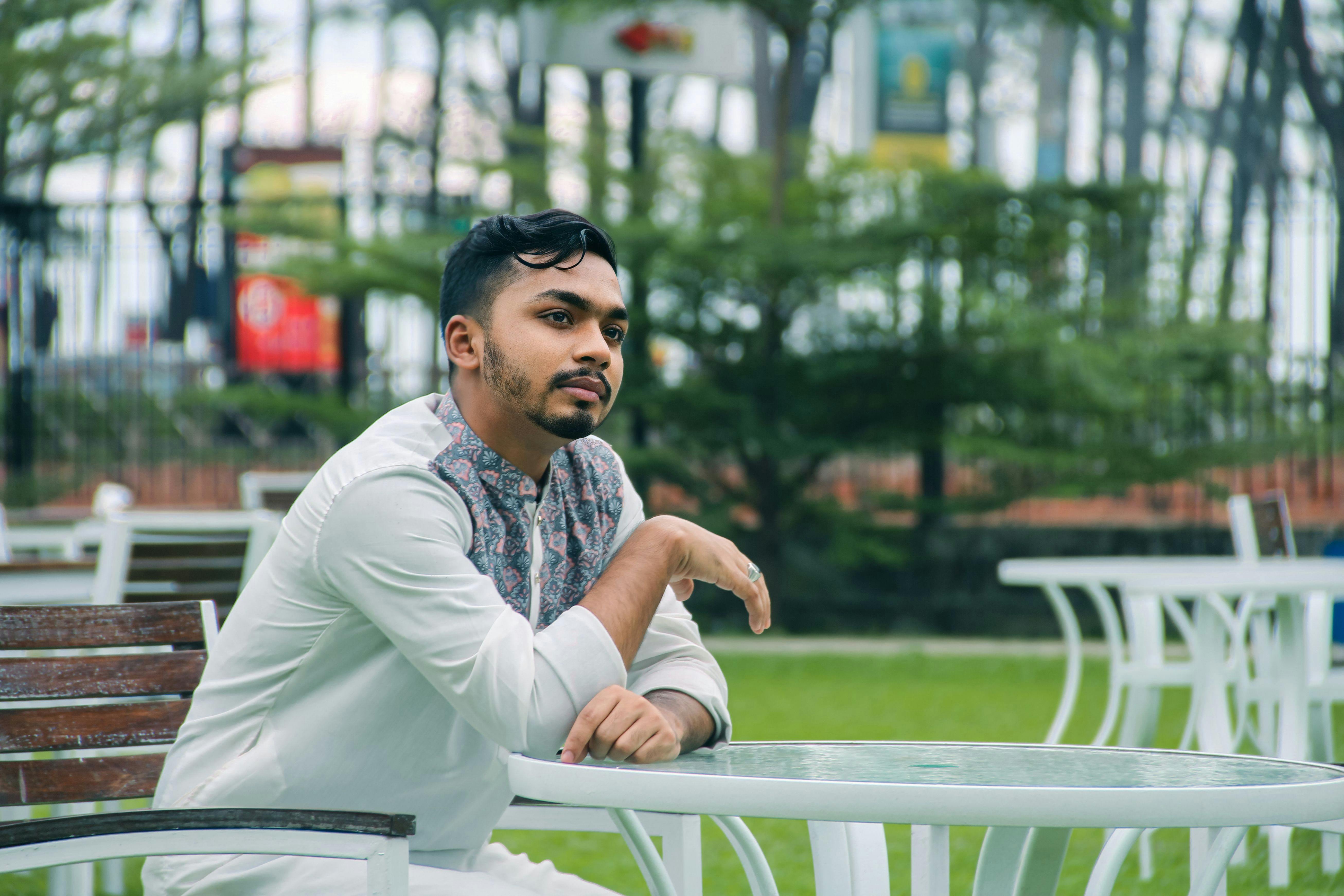 Man Sitting at a Table in the Garden of a Restaurant · Free Stock Photo