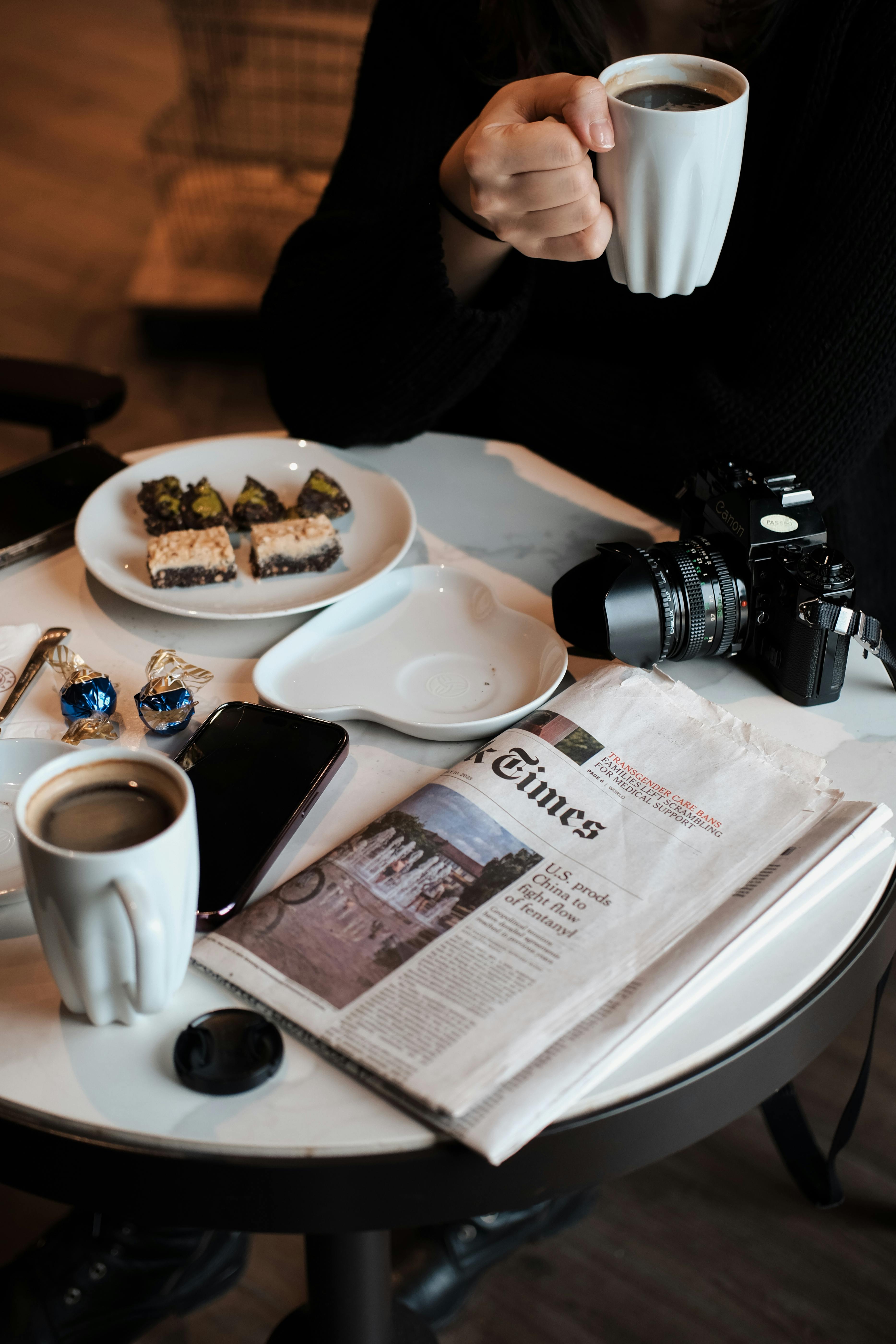 Newspaper, Camera, Plates and Cake on Table · Free Stock Photo