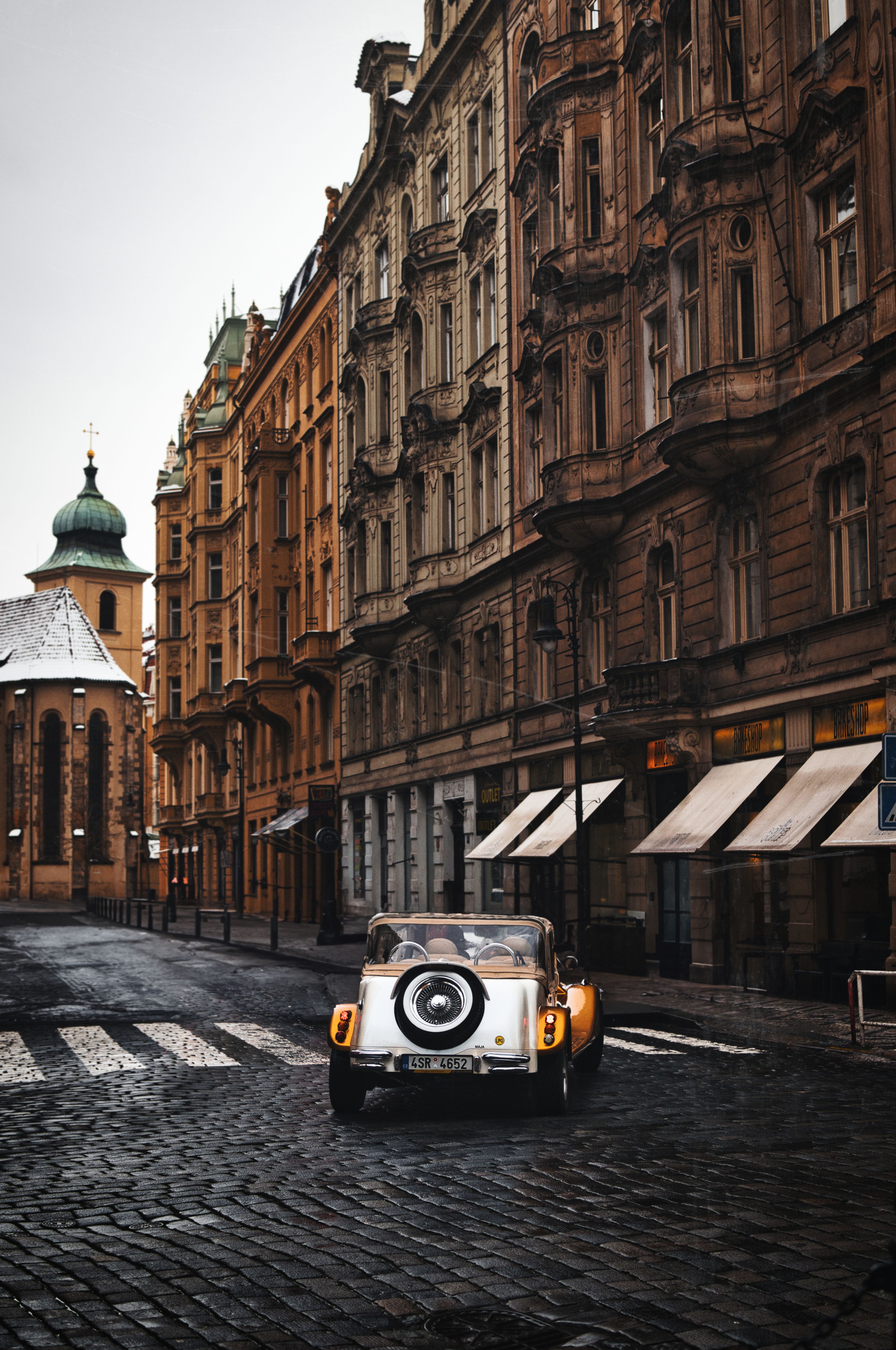Vintage Car Between Classical Buildings · Free Stock Photo