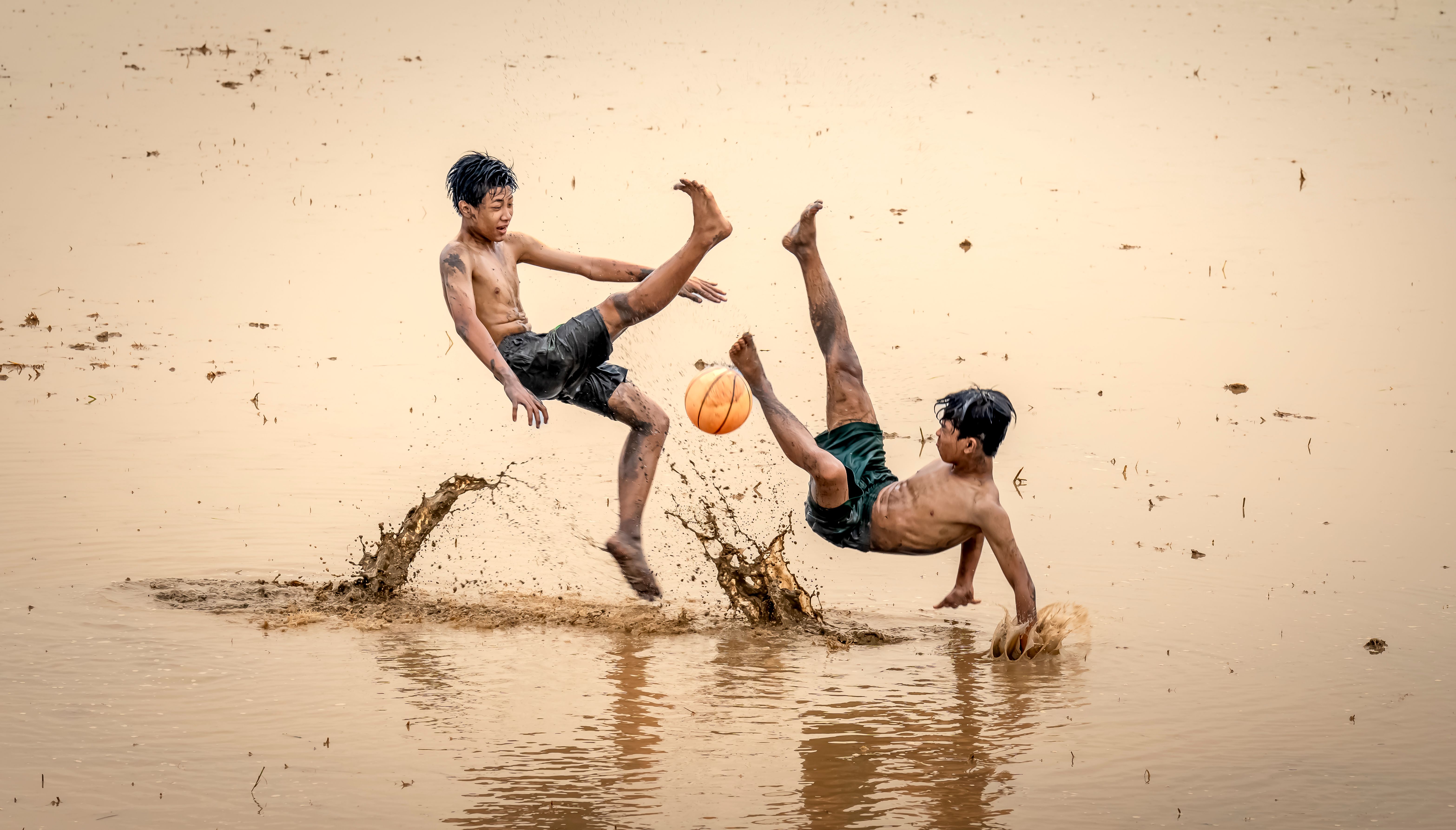 Boys Playing Soccer in Muddy Water · Free Stock Photo