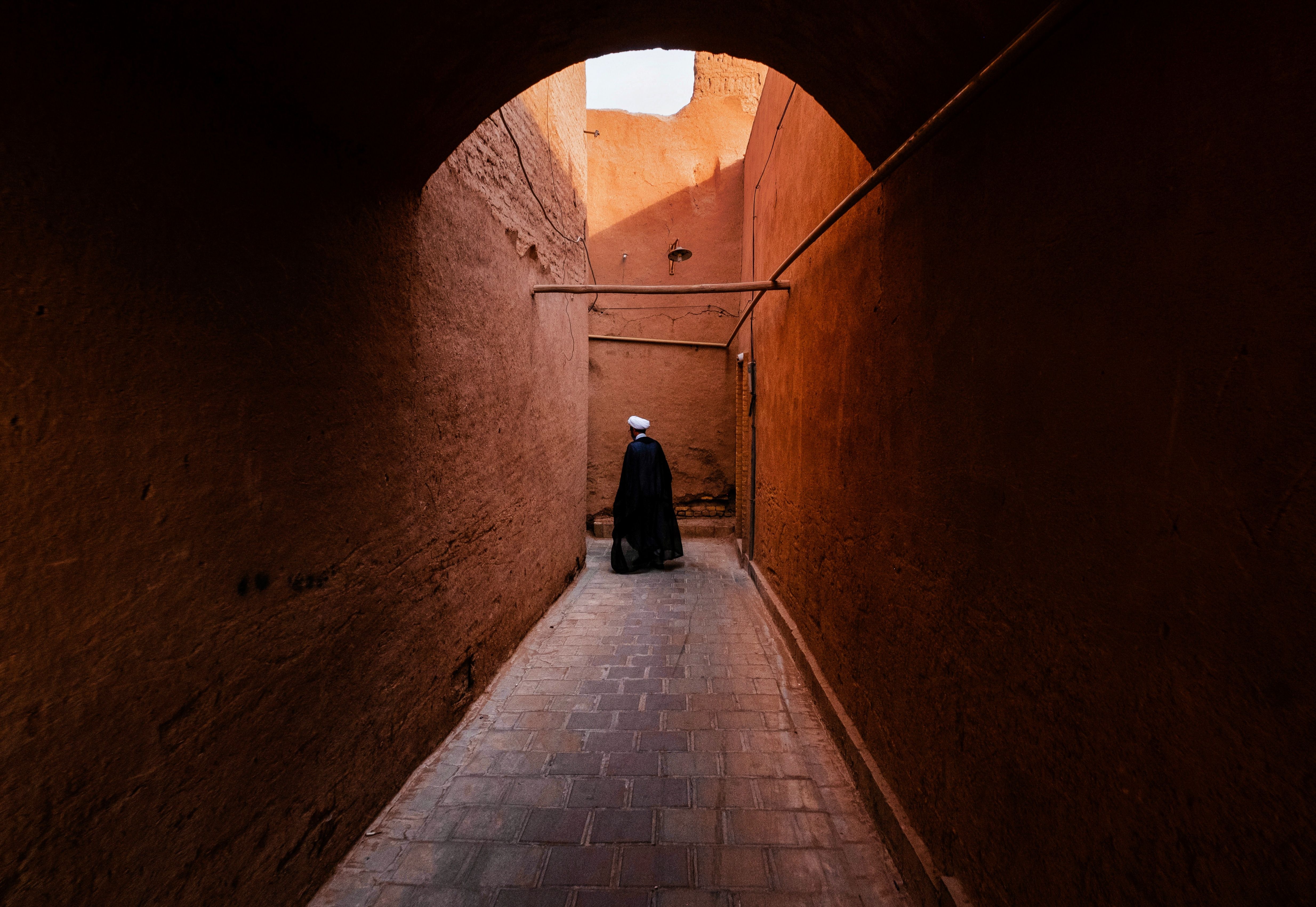 Person in a Black Gown Walking in a Narrow Alley between Buildings ...
