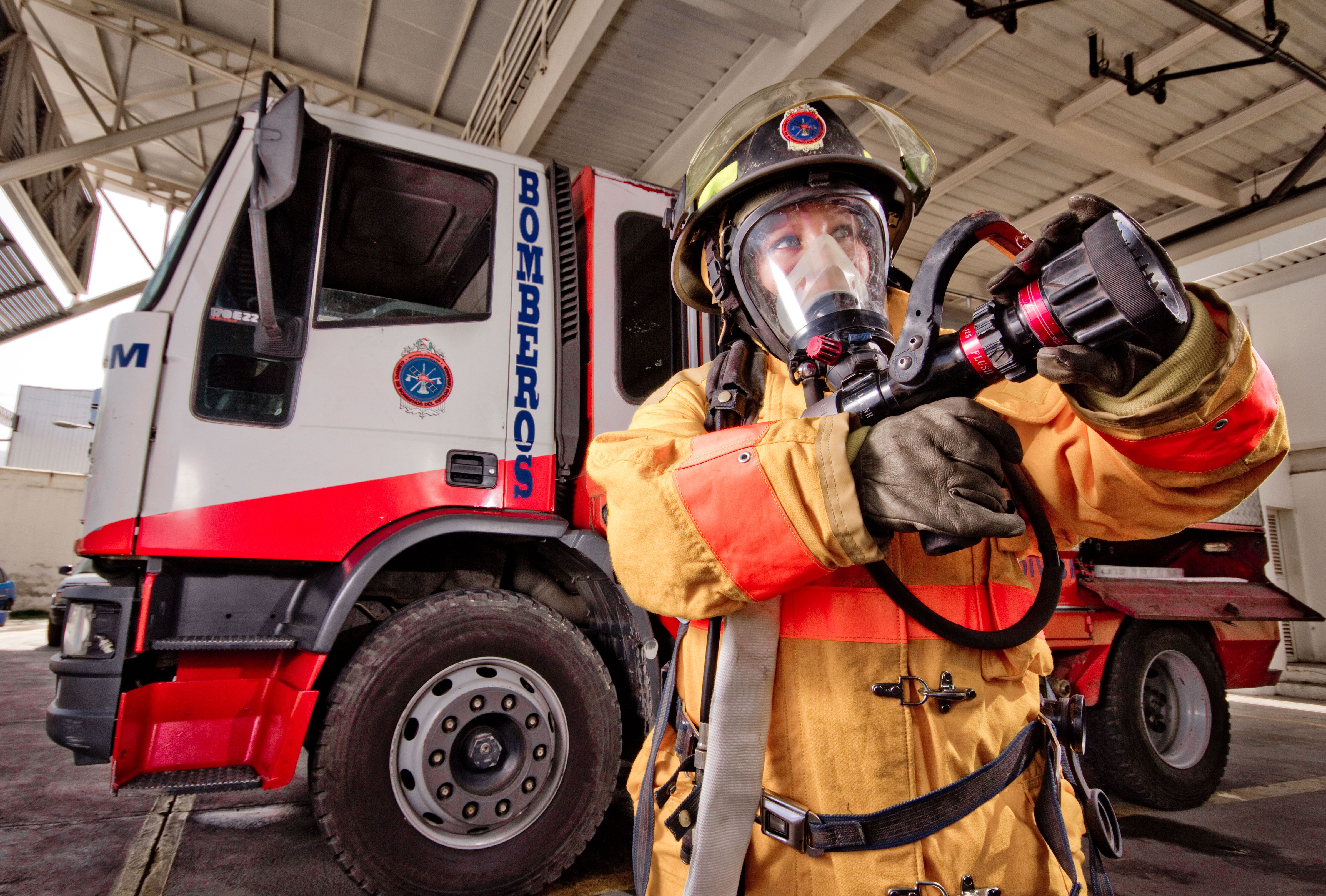 Grayscale Photography of a Fireman On The Fire Truck Ladder Hosing ...