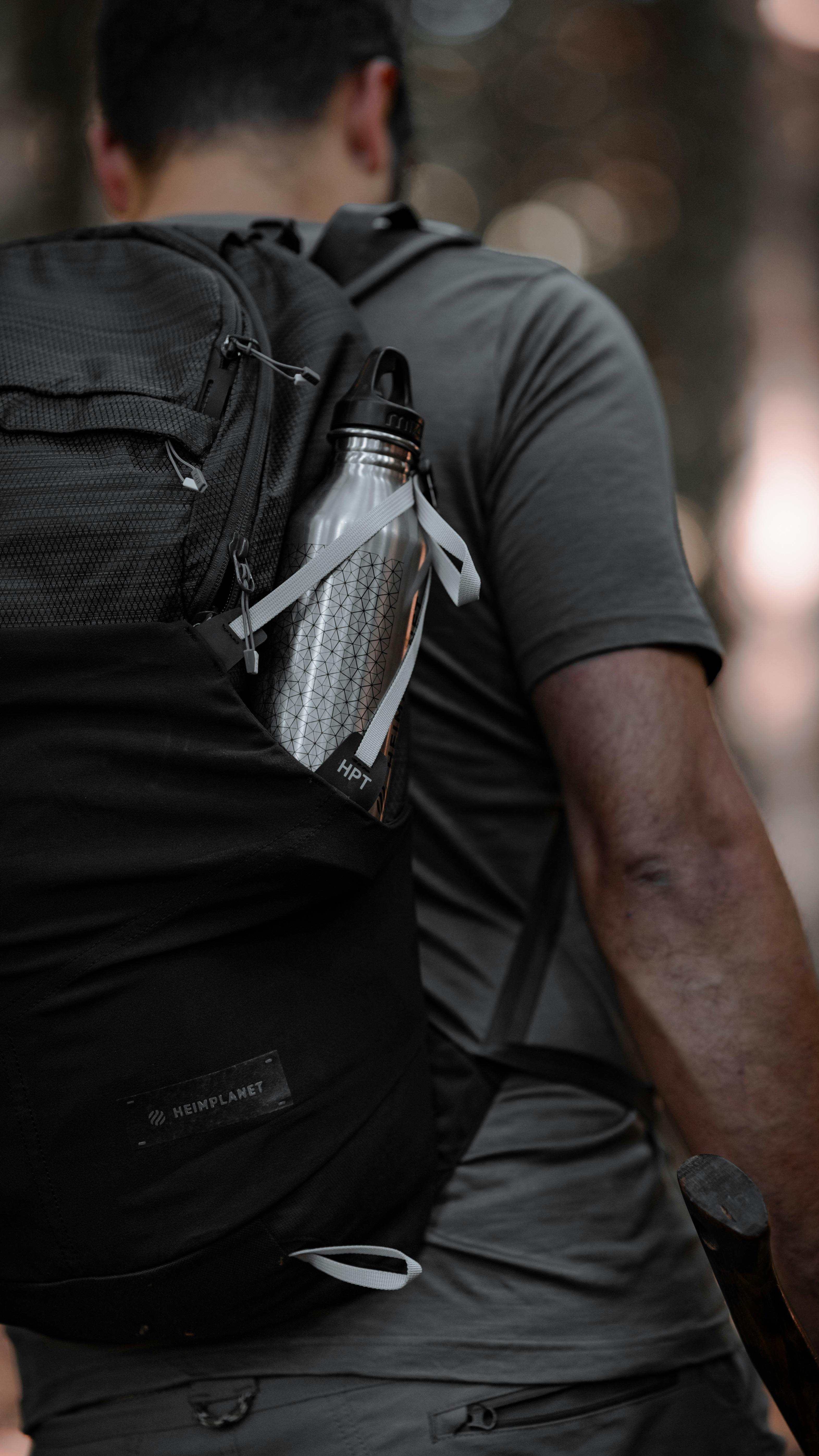 Back View of Man Hiking with Backpack and Thermos · Free Stock Photo