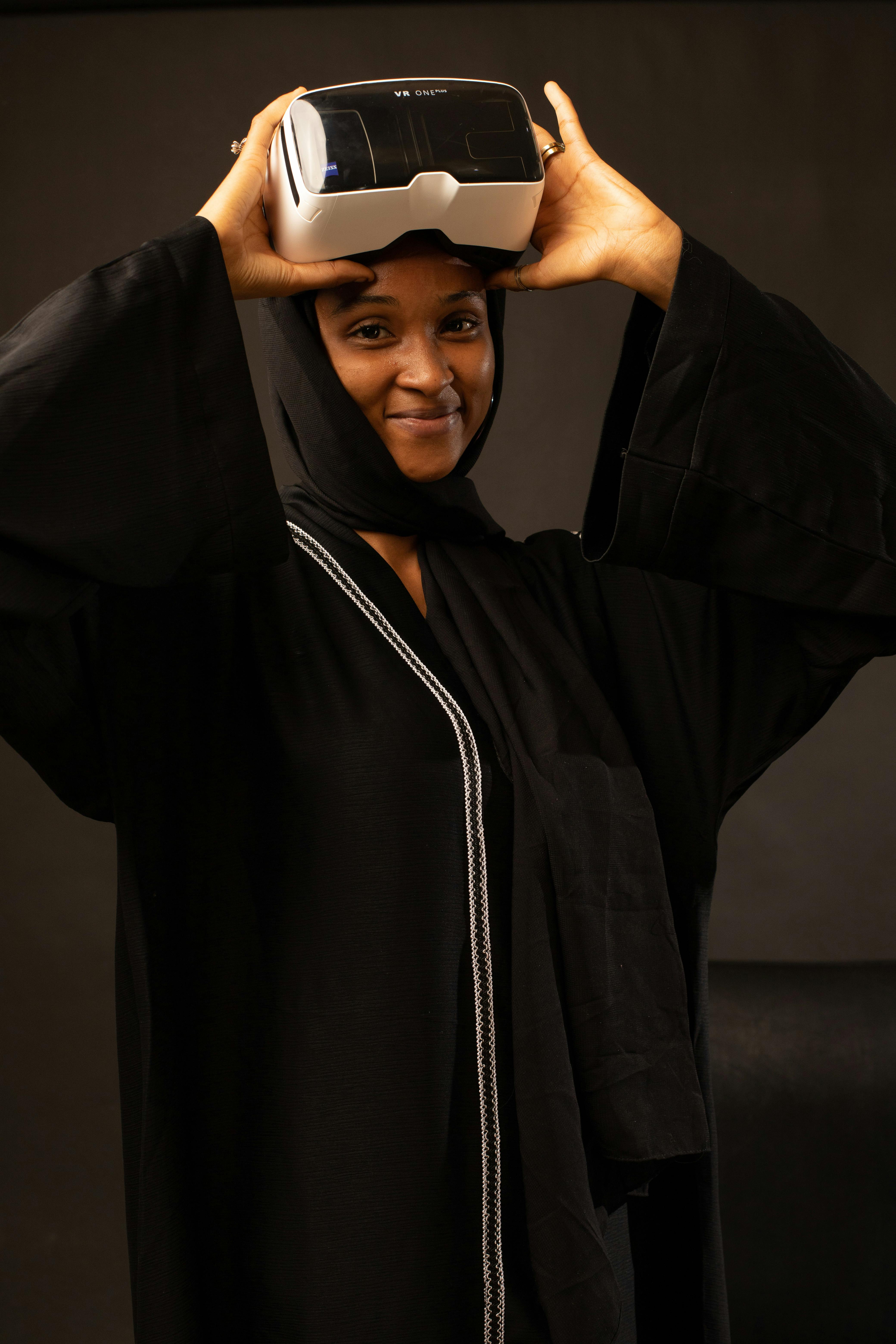 Traditionally Dressed Woman Putting on VR Goggles · Free Stock Photo