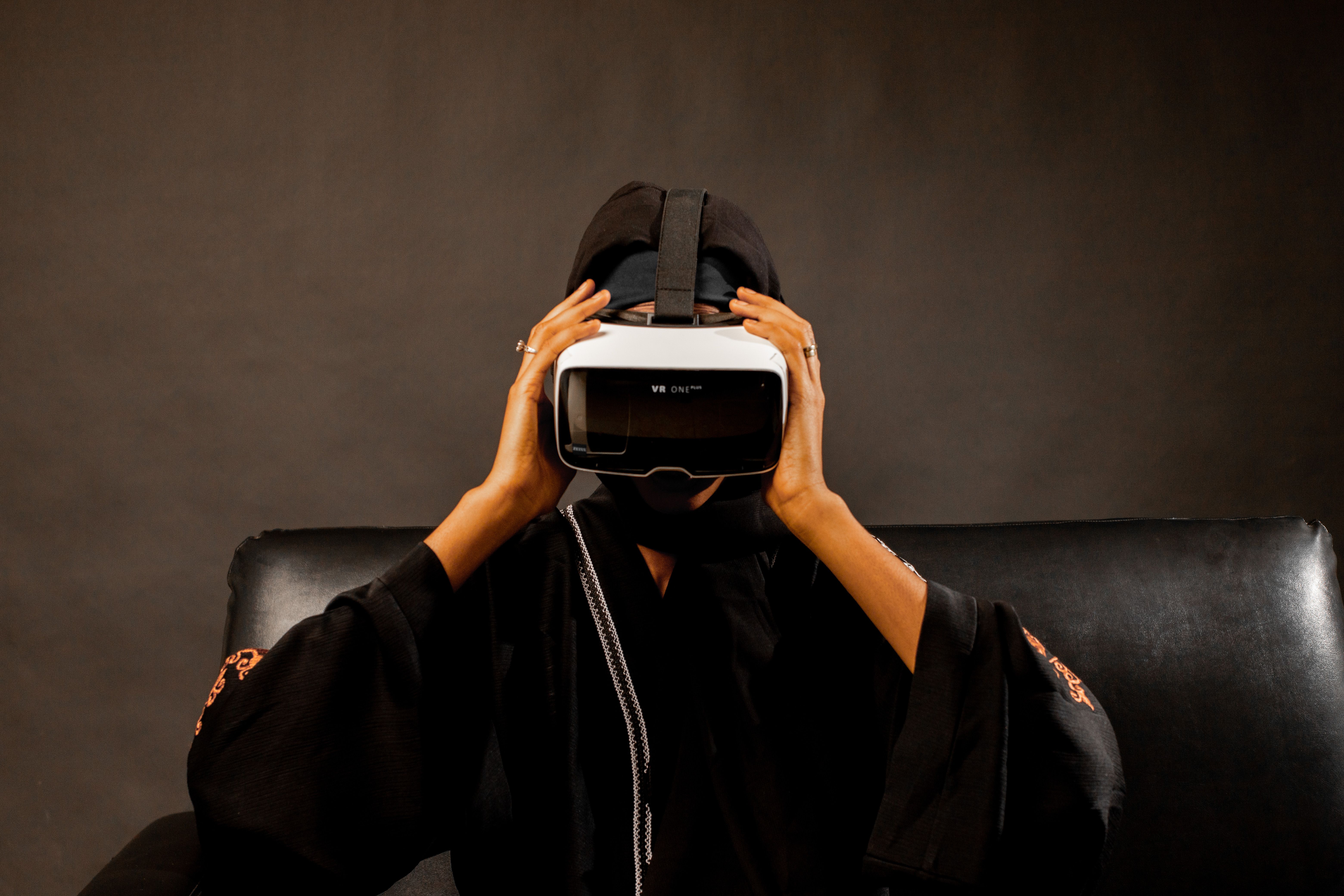 Woman in VR Glasses Sitting on Leather Sofa · Free Stock Photo