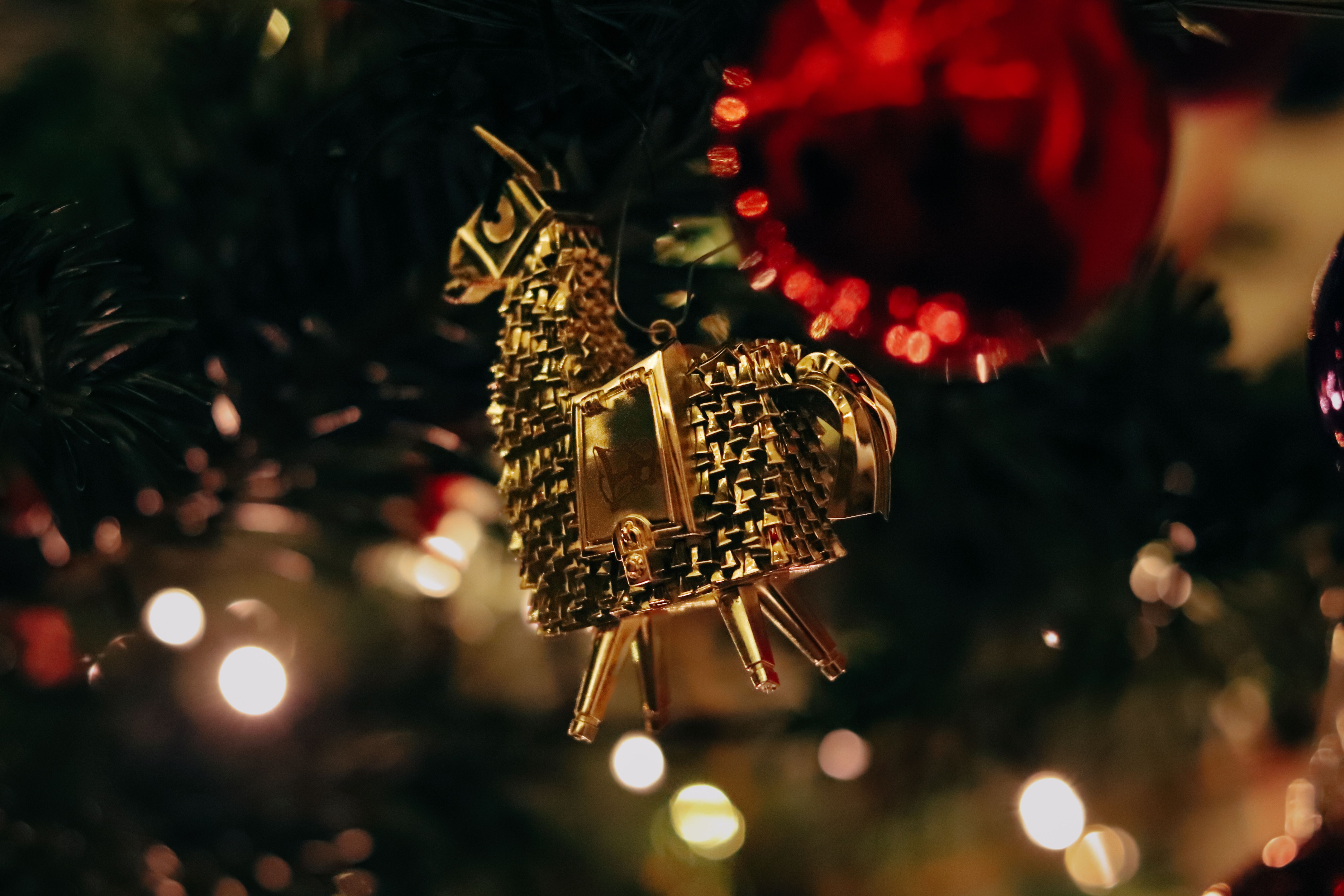 A gold llama ornament hanging from a christmas tree · Free Stock Photo