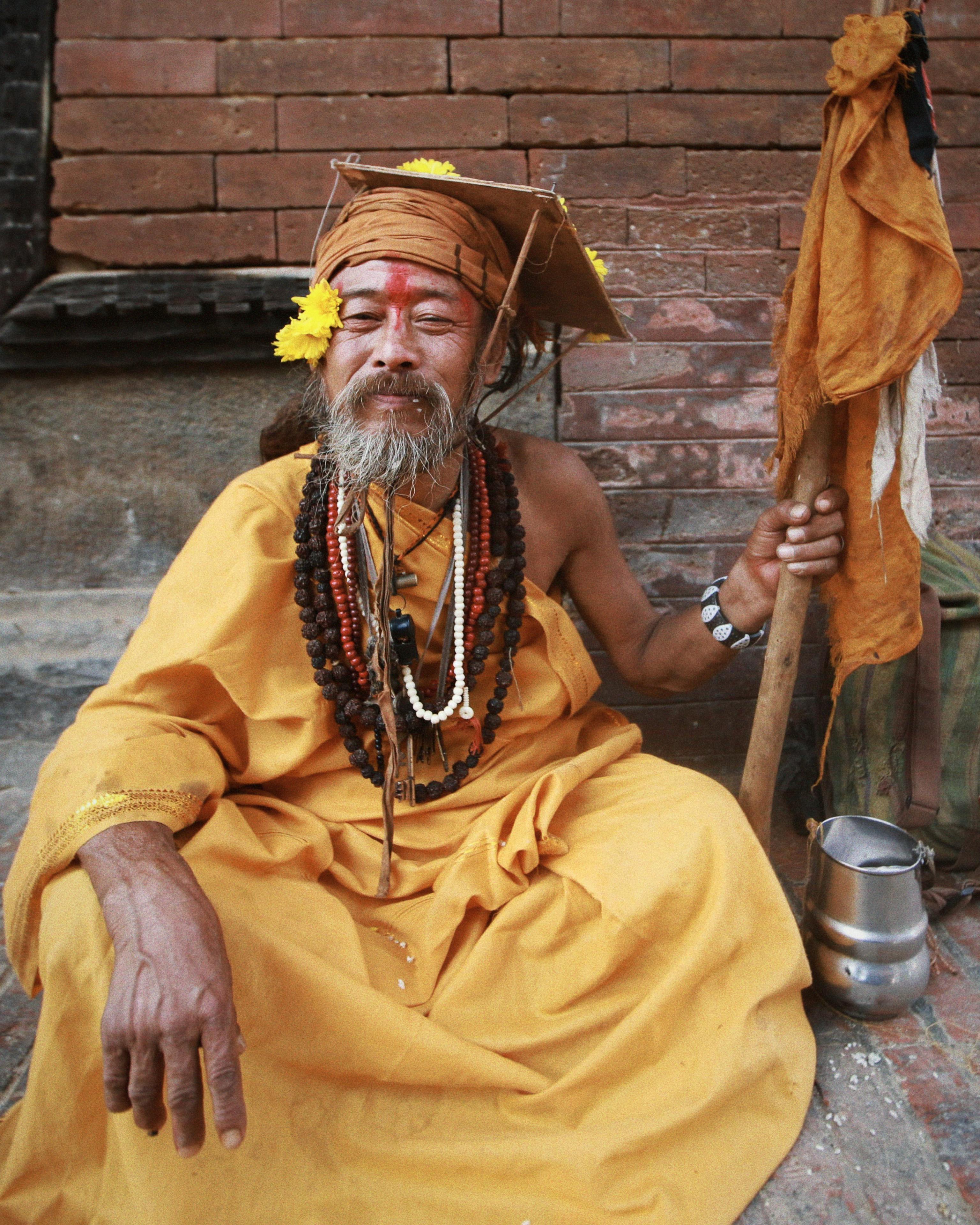 A Monk Sitting on the Ground · Free Stock Photo