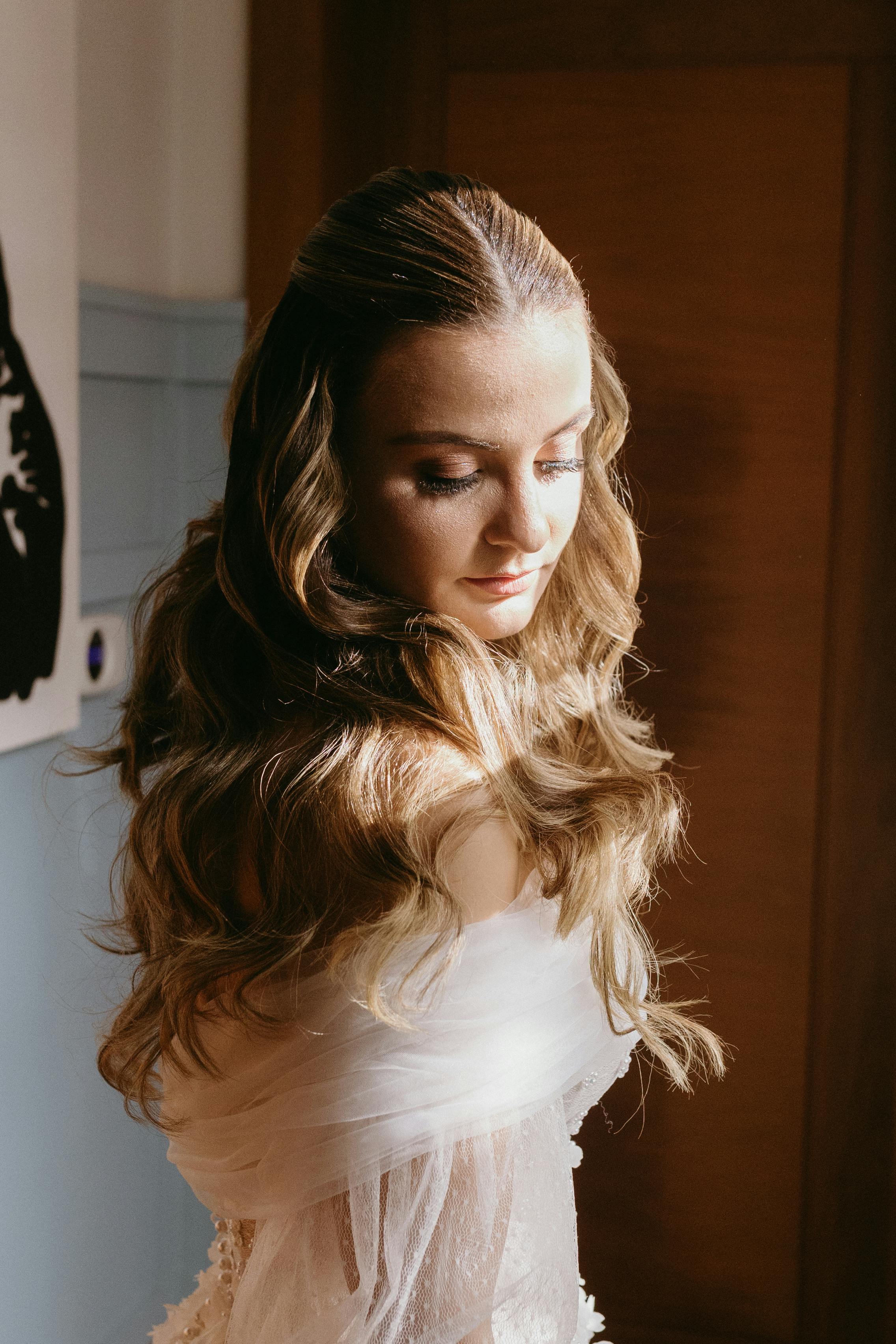 Bride Standing in Sunlight and Looking Down · Free Stock Photo