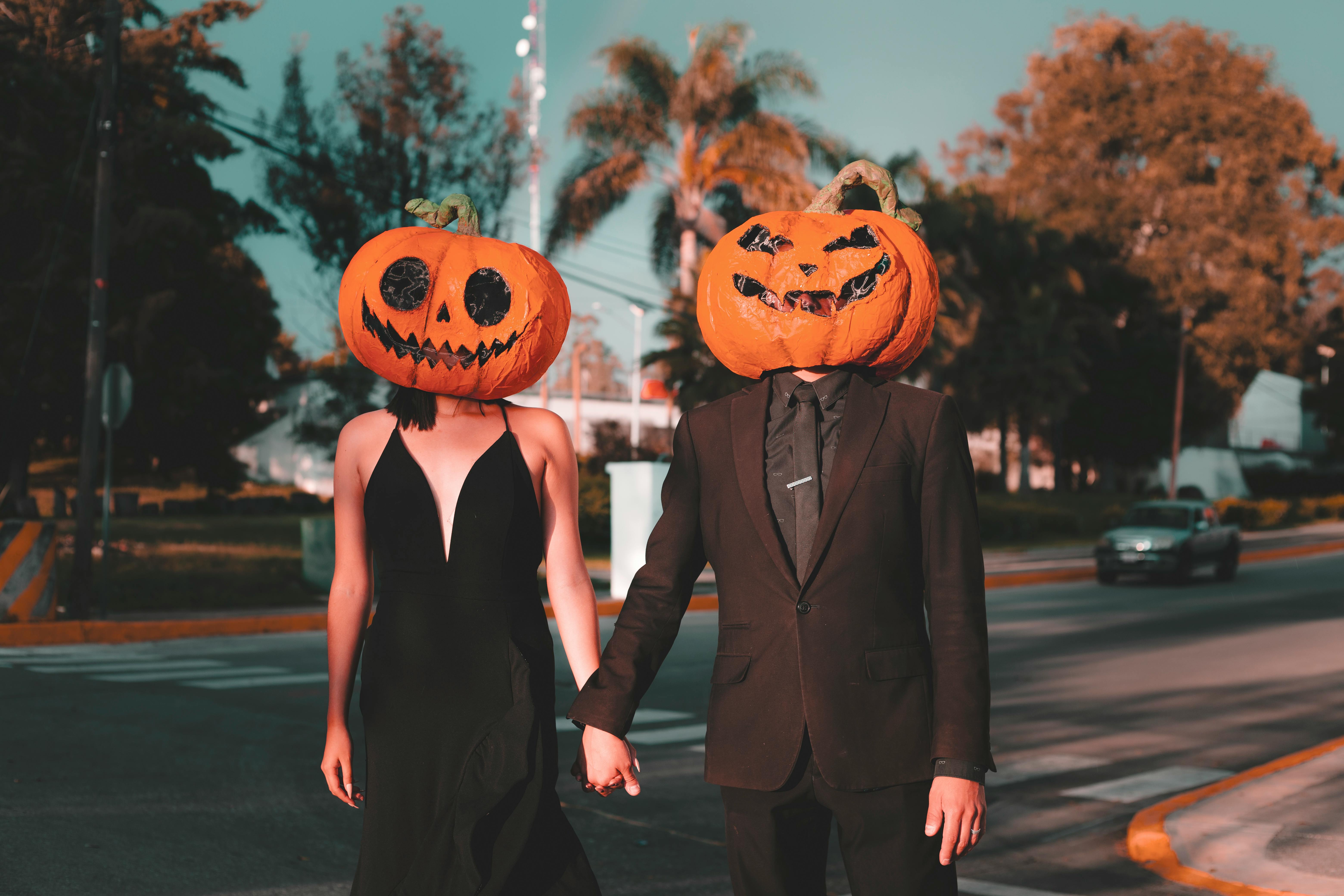 Couple Wearing Pumpkin Masks Walking on a Street · Free Stock Photo