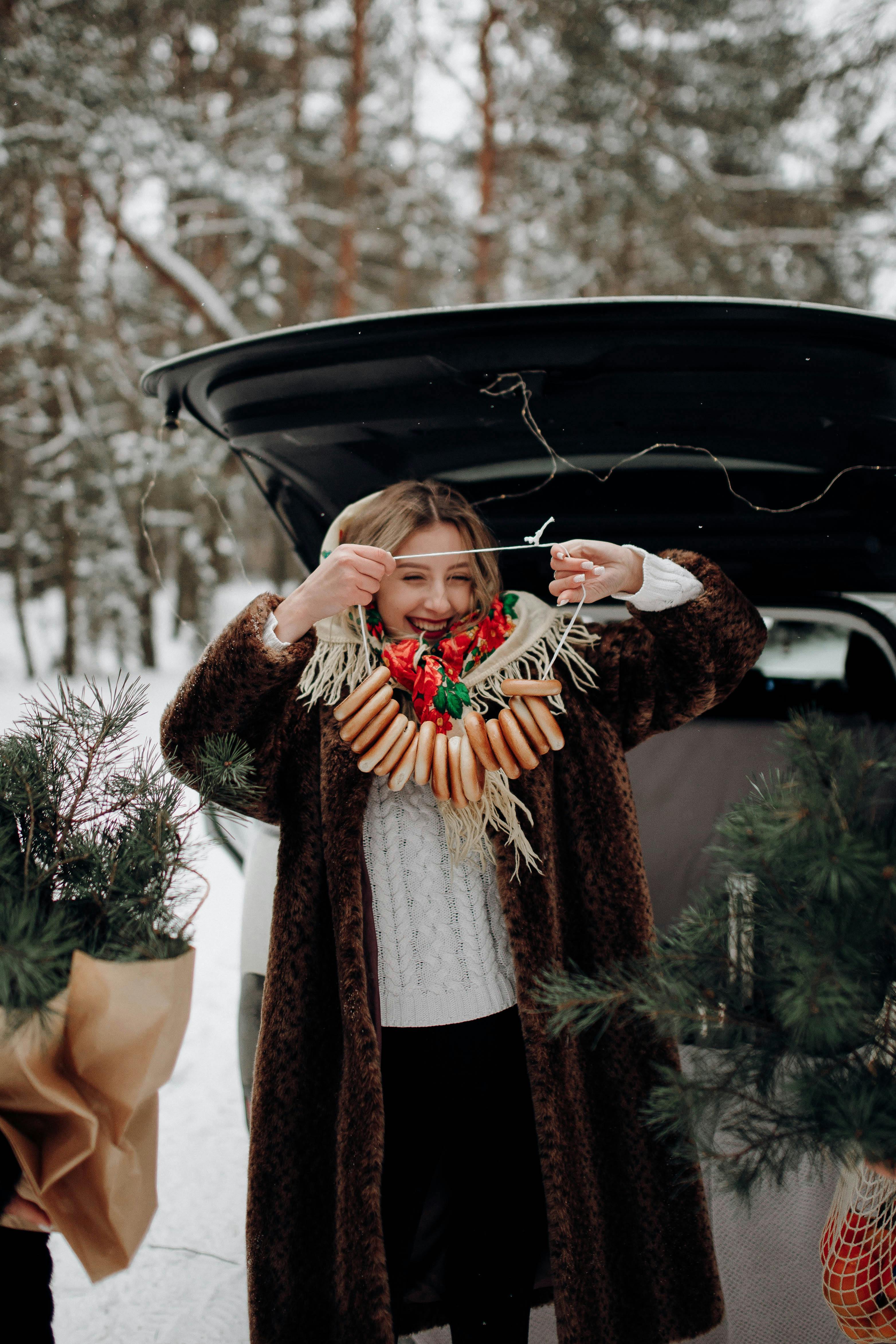 Smiling Woman Holding Pretzels on String · Free Stock Photo