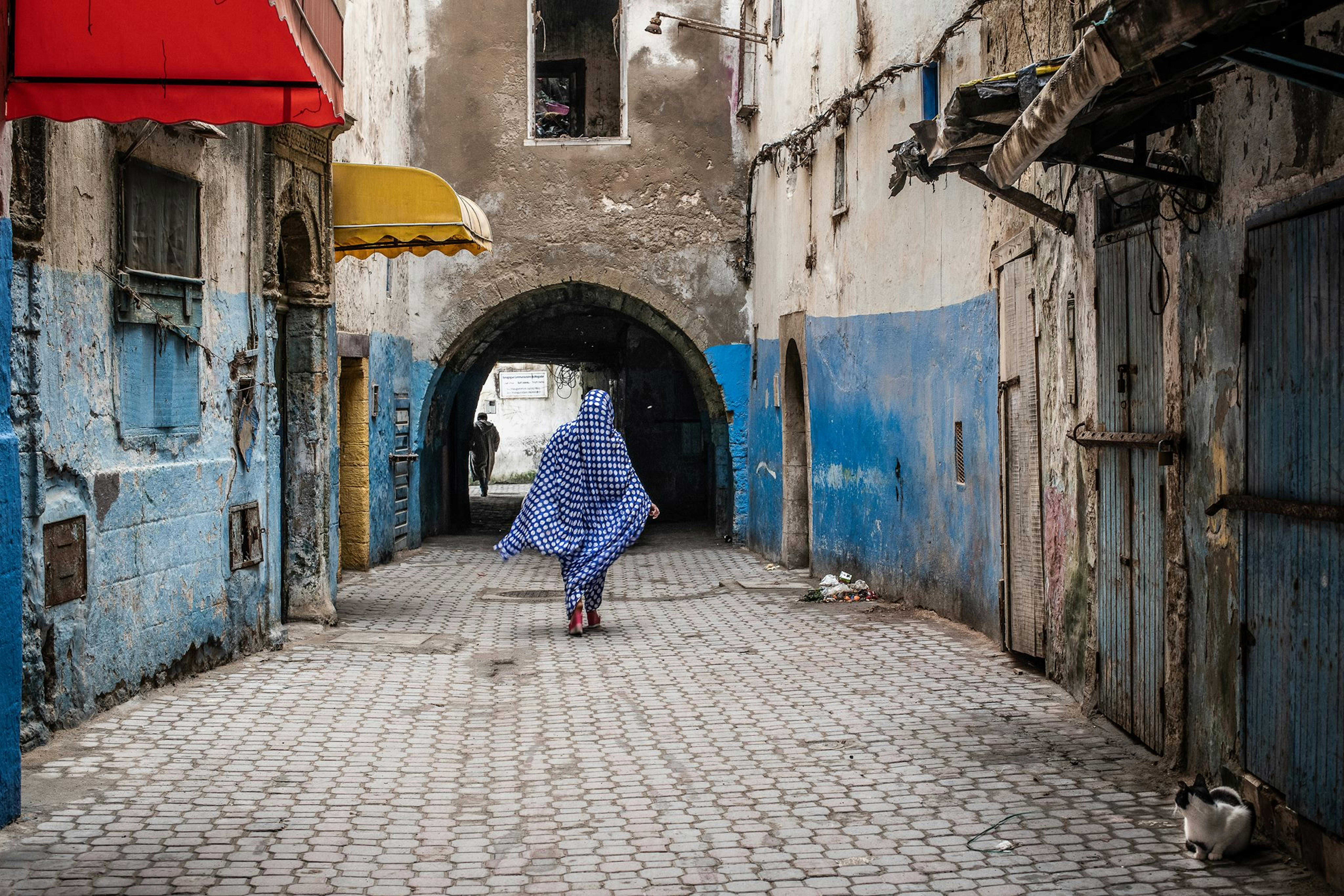 Back of a Woman Wearing a Polka Dot Jilbab Walking along a Paved Alley ...