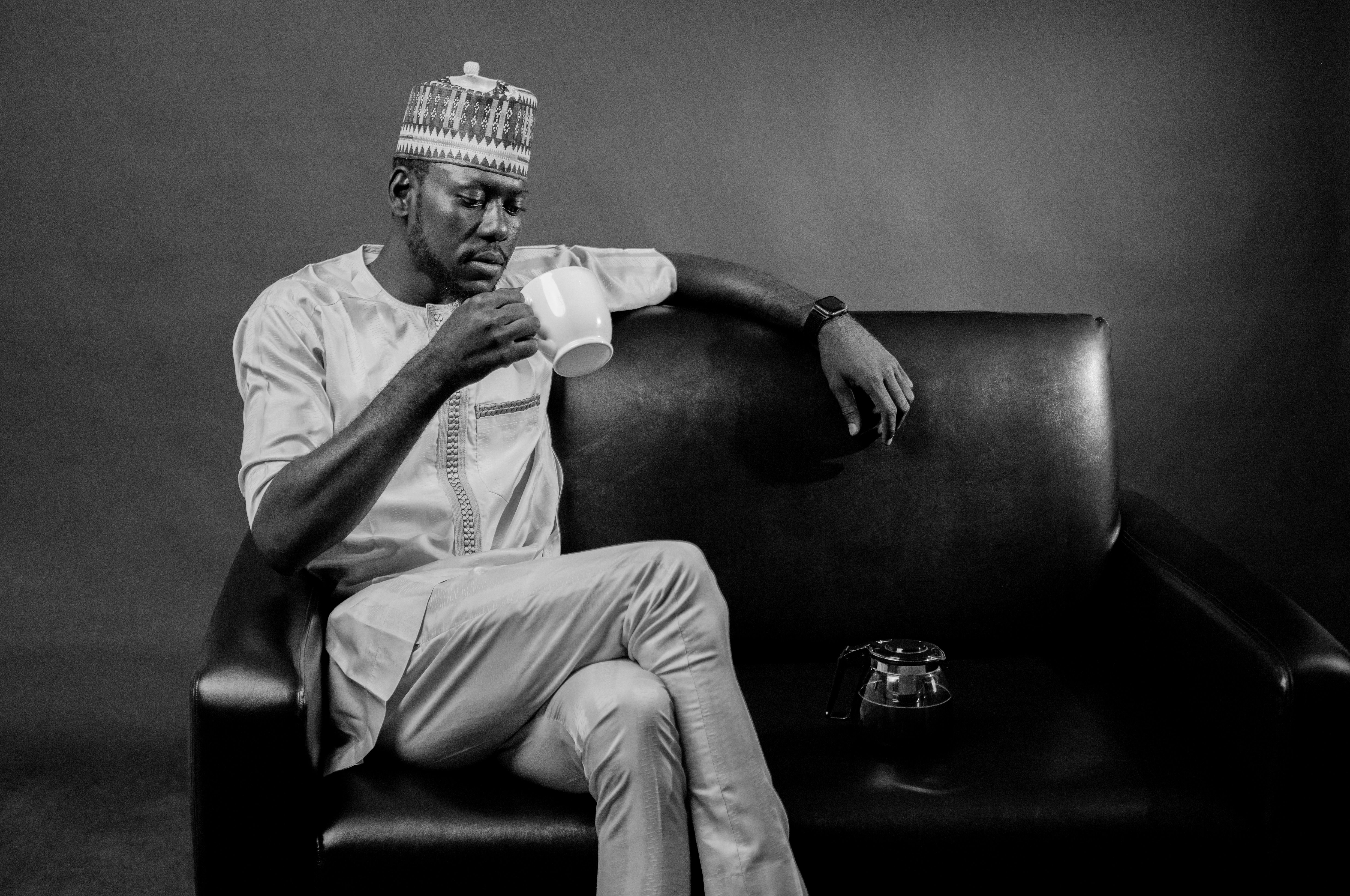 Man Wearing Traditional Hat Sitting on Sofa in Black and White · Free ...