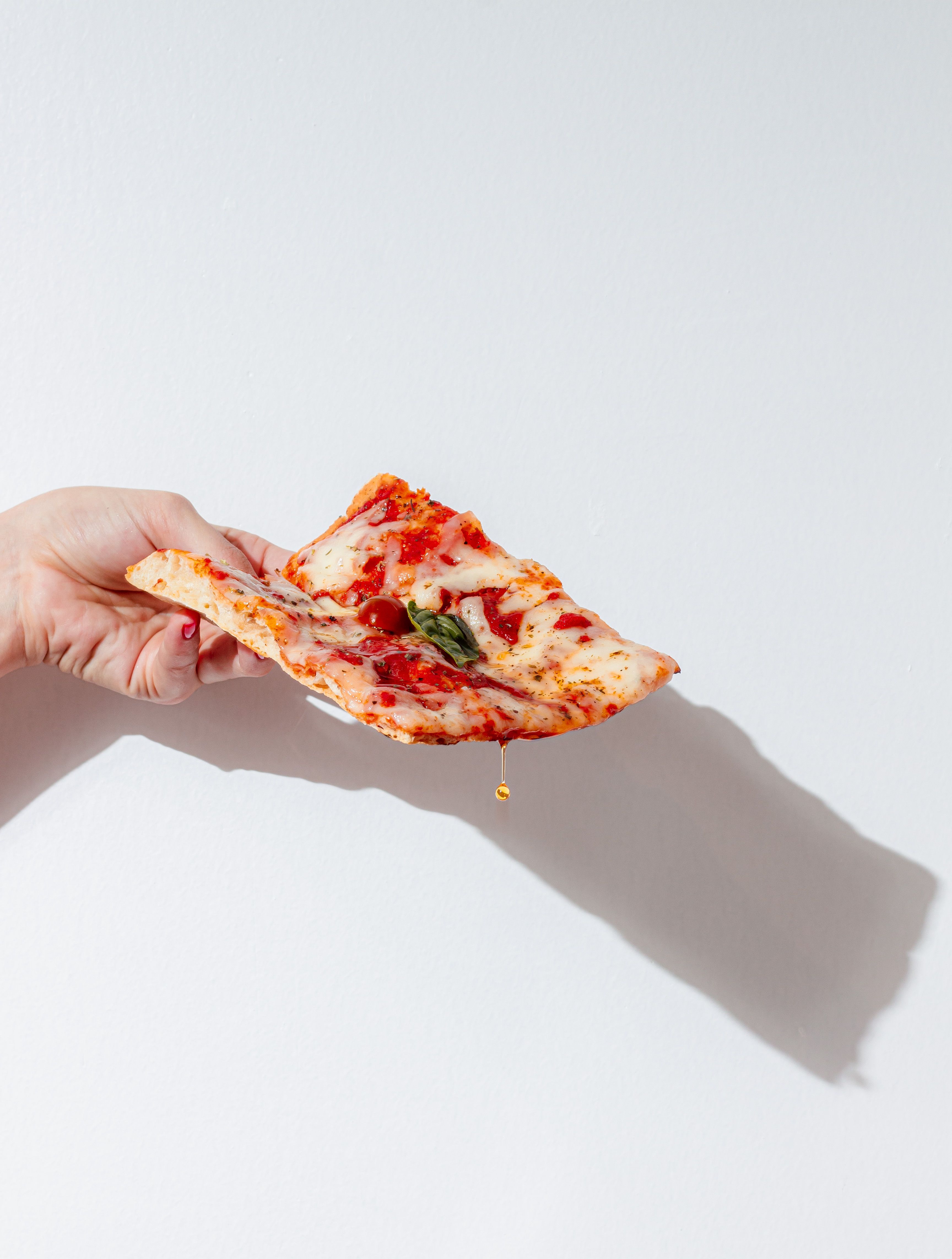 Woman Hand Holding Pizza Slice · Free Stock Photo