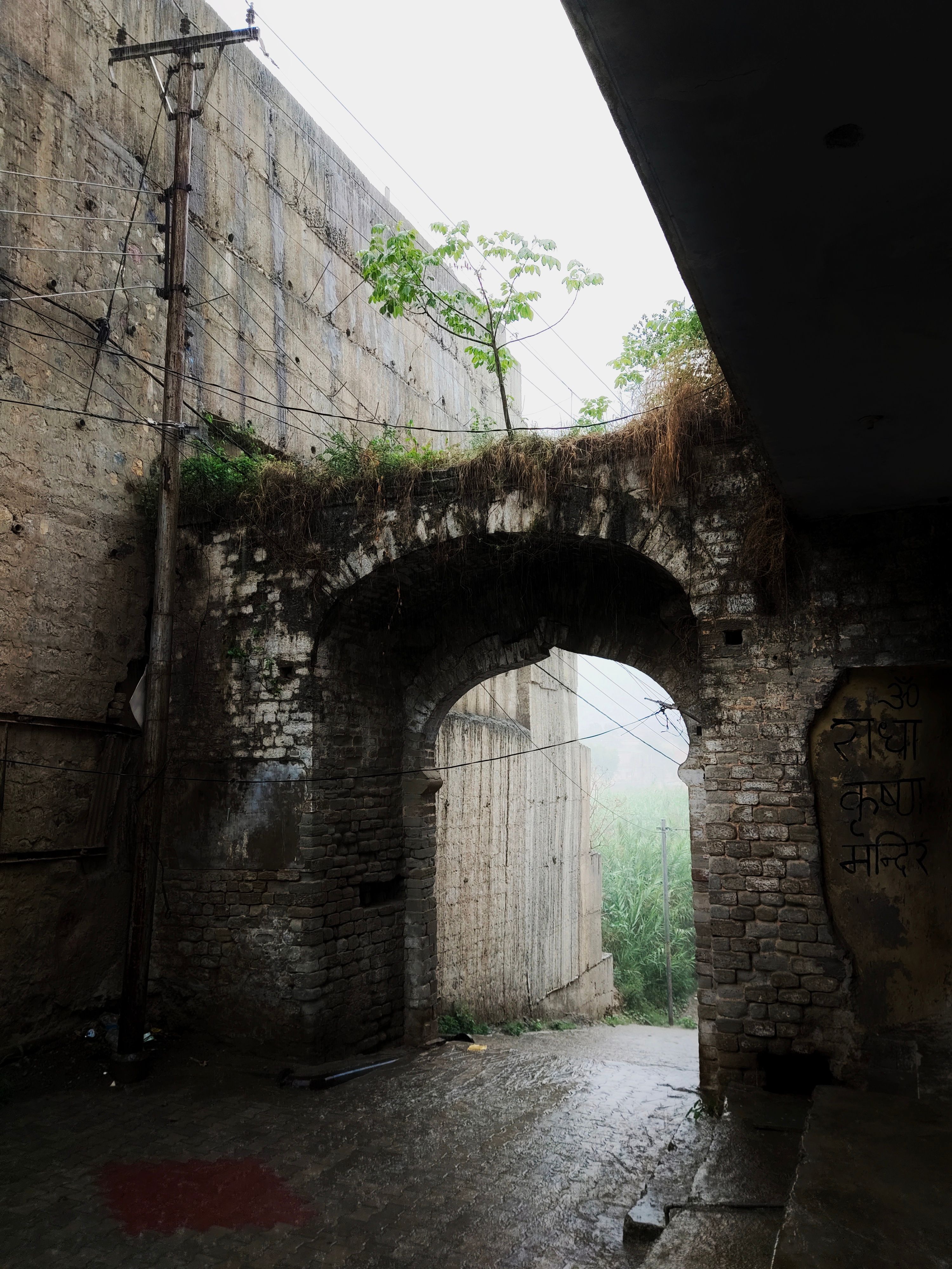 View of a Walkway under an Abandoned Arch · Free Stock Photo