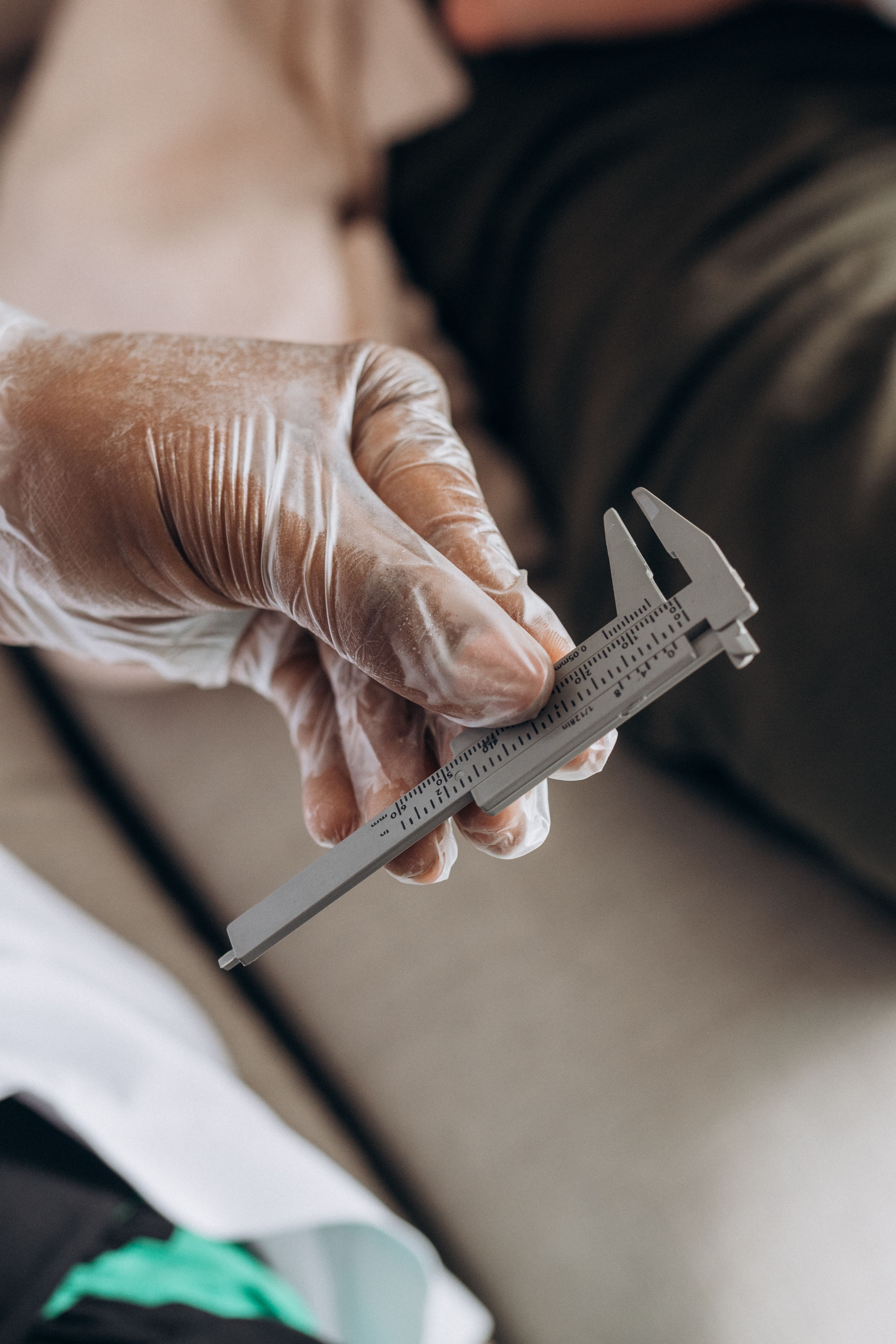 A person in gloves holding a measuring tool · Free Stock Photo