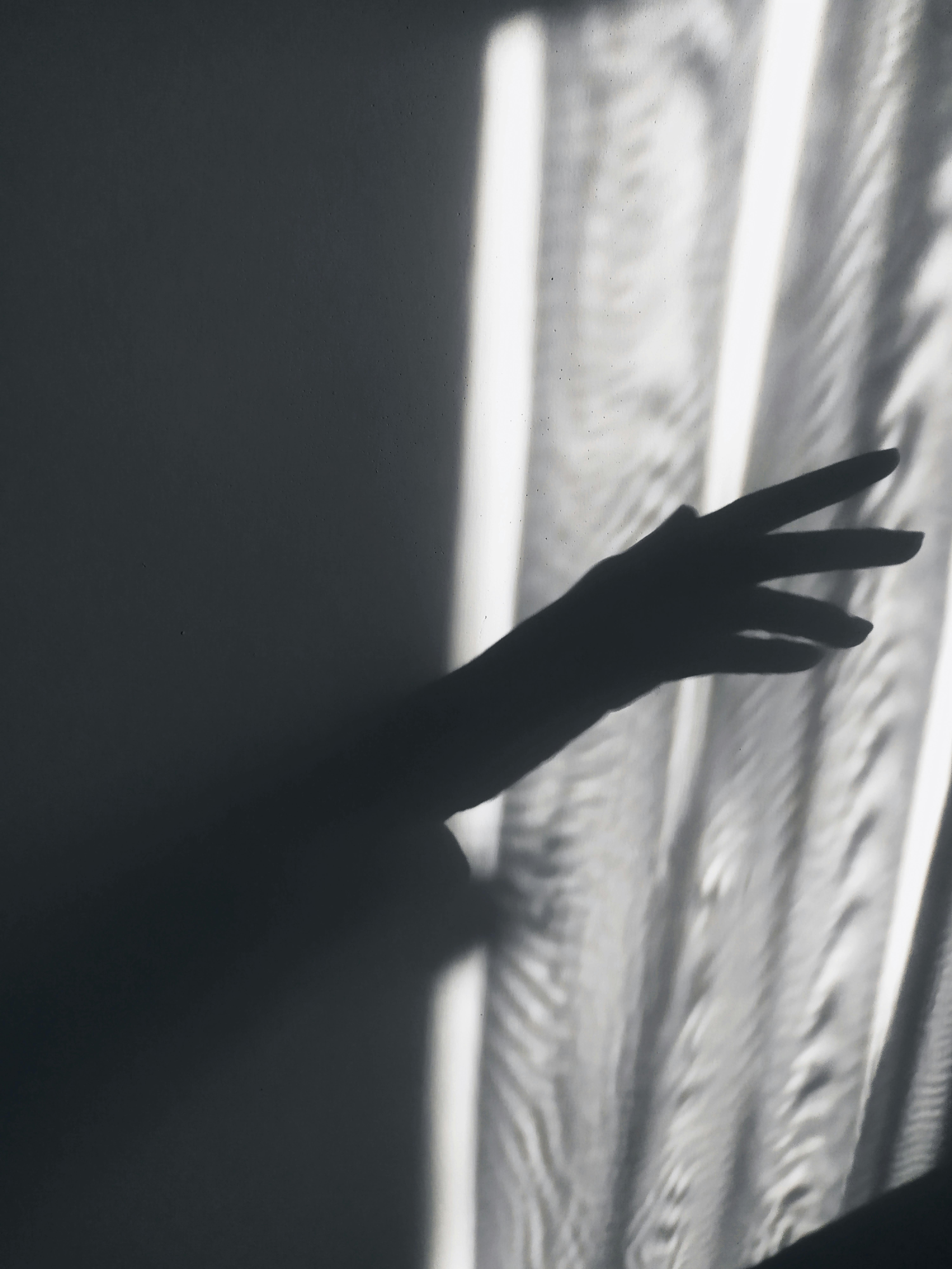 Womans Hand on the Window Curtain · Free Stock Photo