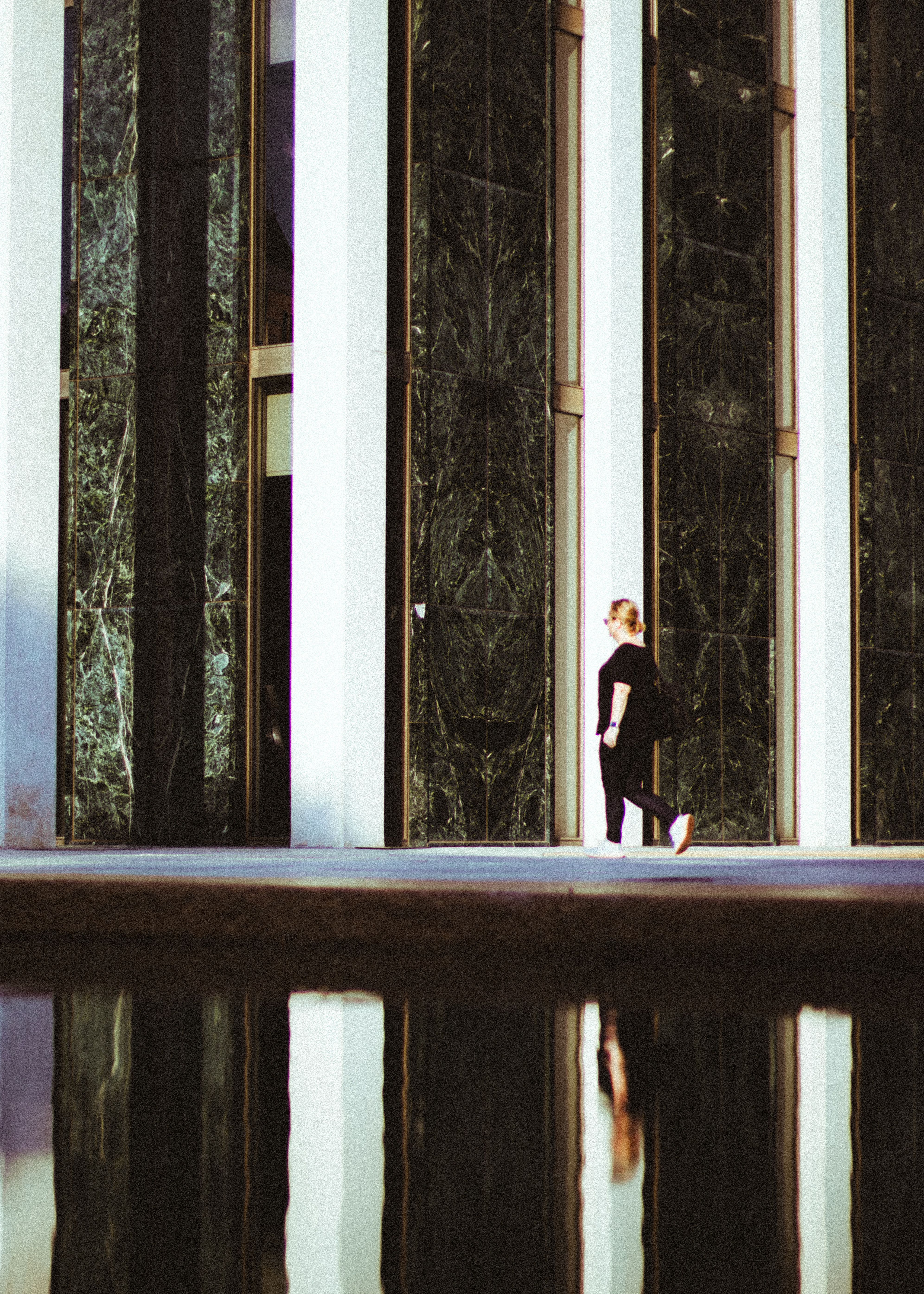 Woman Walking by a Marble Building · Free Stock Photo