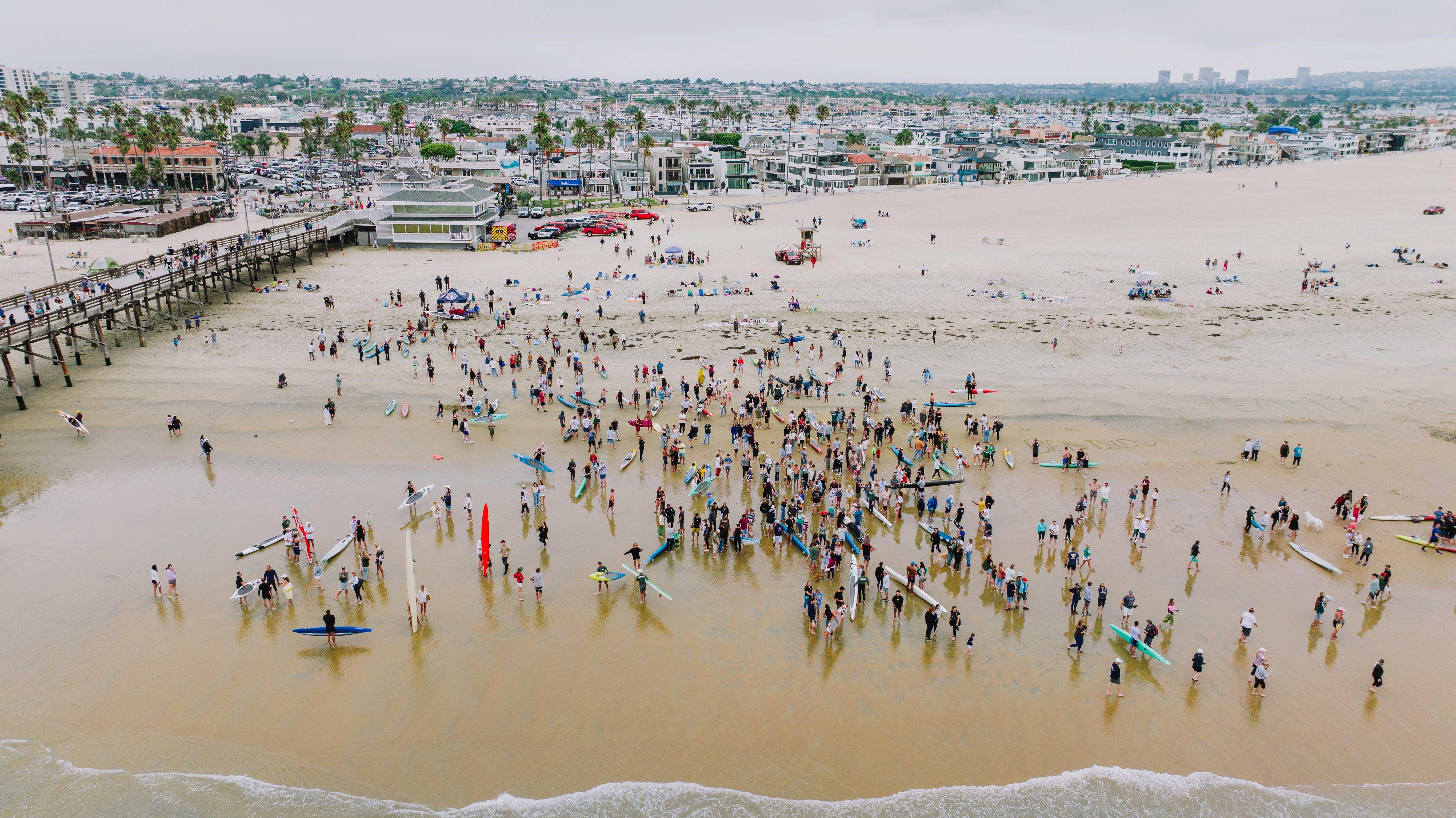 A large crowd of people on the beach with surfboards · Free Stock Photo