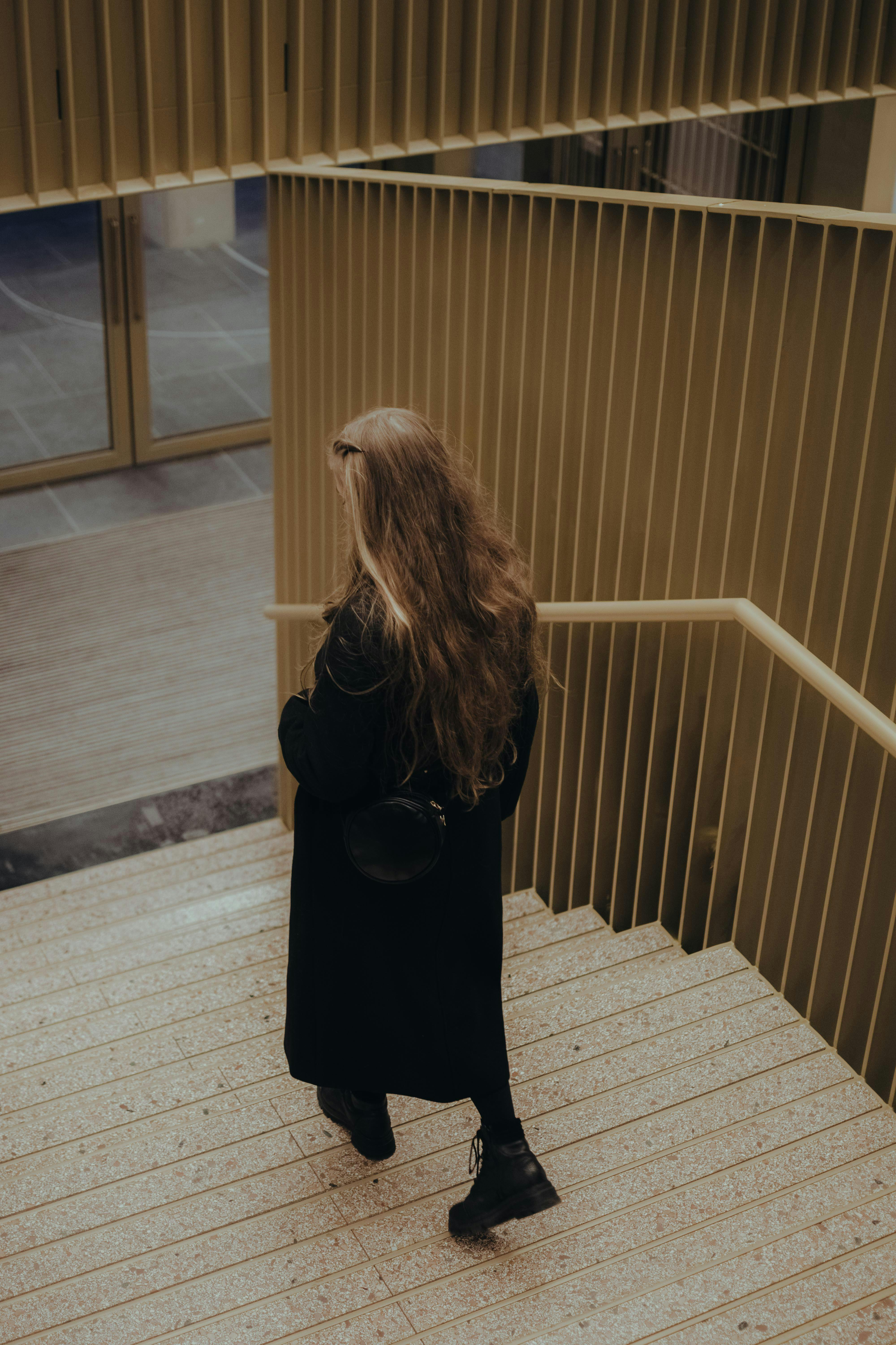 Back View of a Woman Walking Down the Stairs · Free Stock Photo