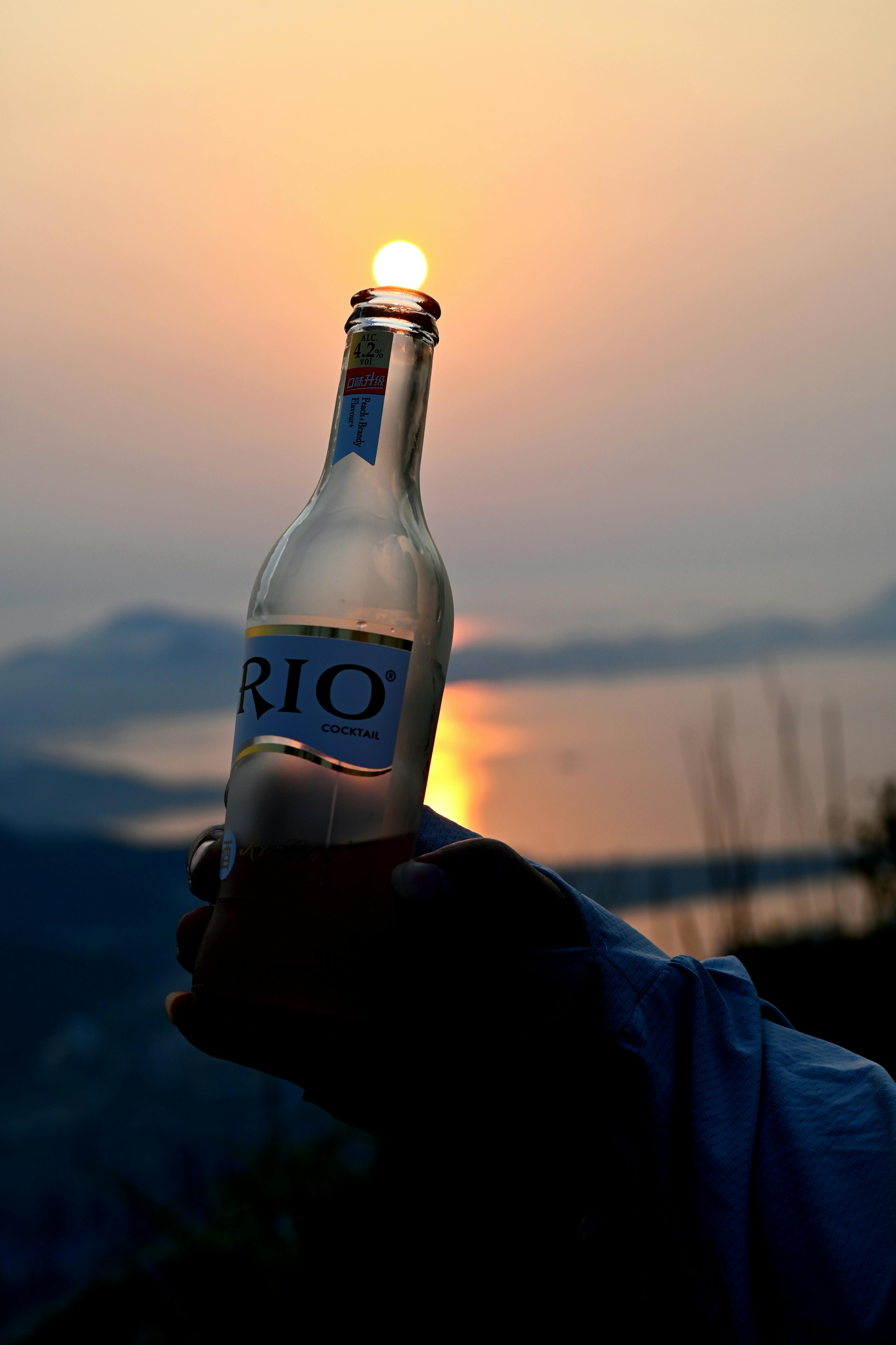 Bottle of Rio Cocktail with a Setting Sun at the Neck · Free Stock Photo