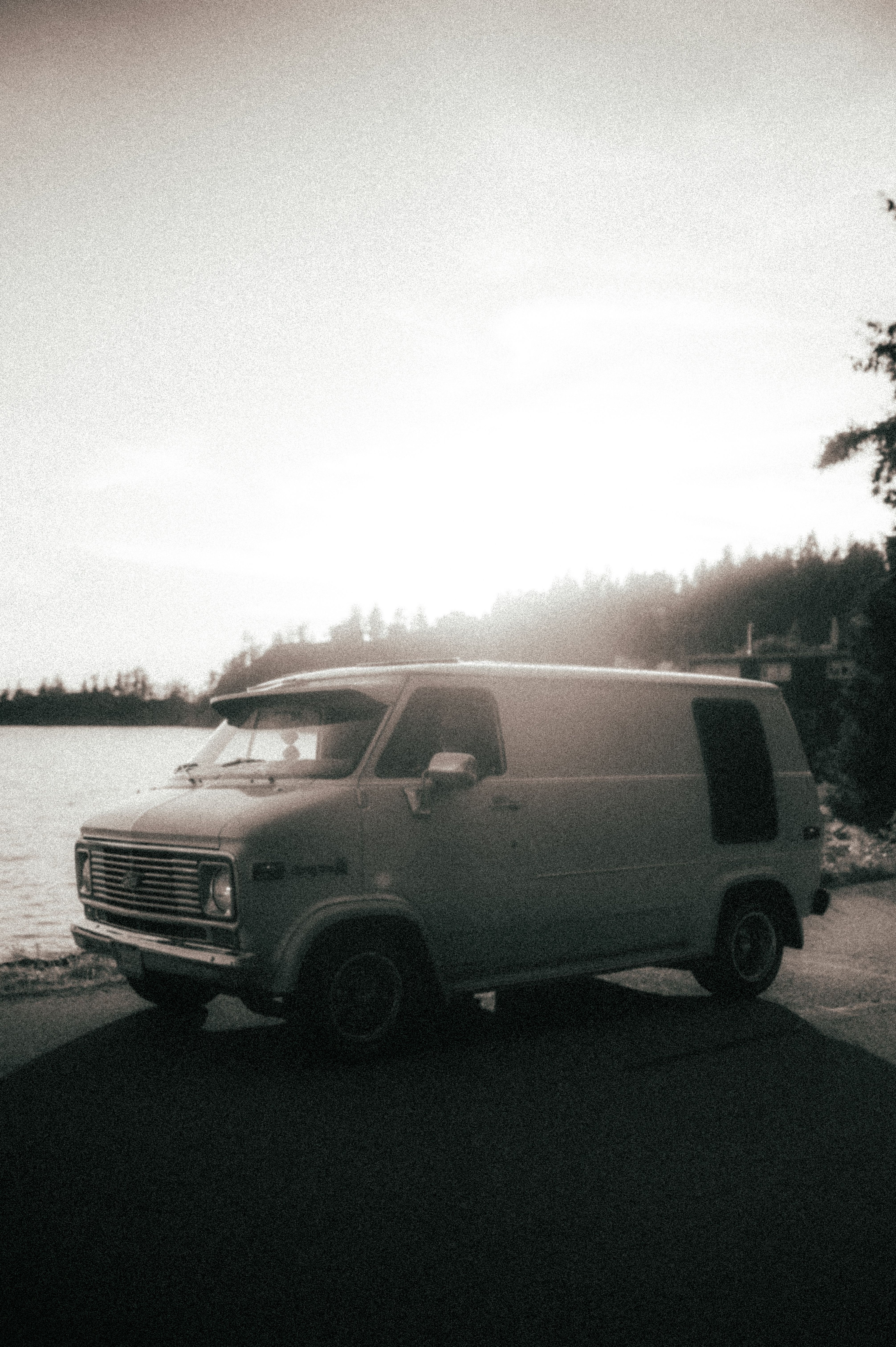 A van parked on the side of the road by the water · Free Stock Photo
