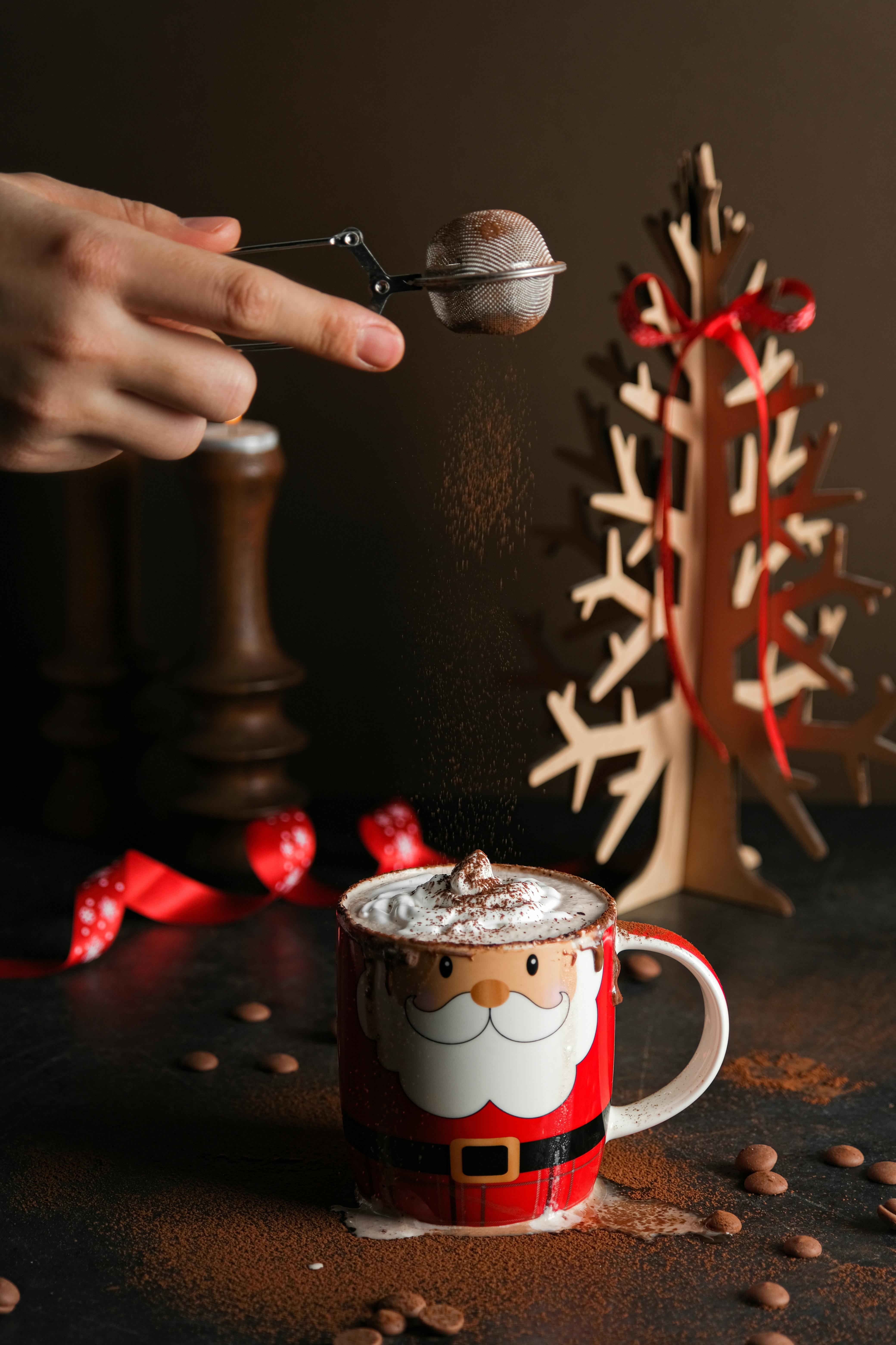 Adding Cocoa Powder to Coffee Cup for Christmas · Free Stock Photo