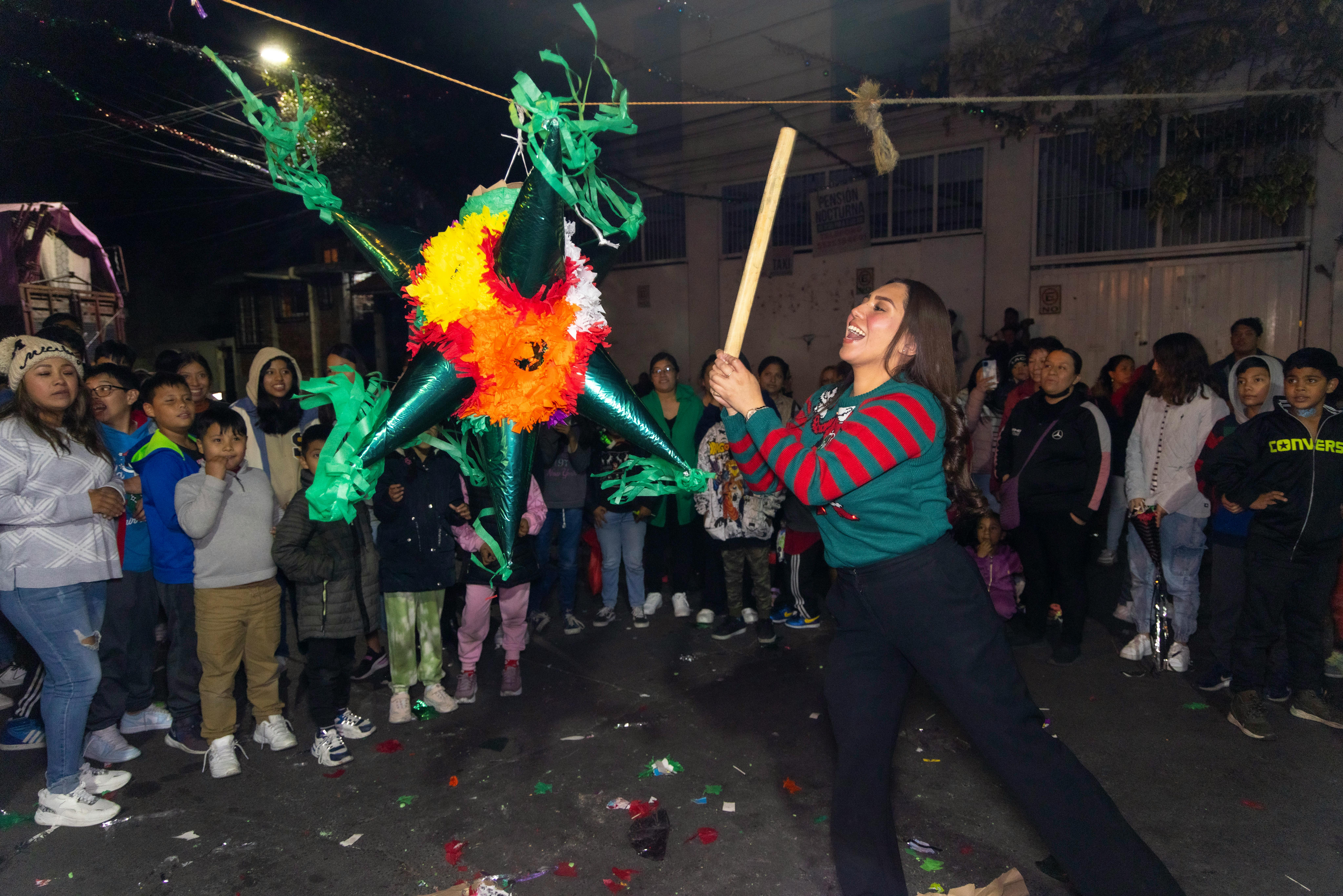 People Watching a Woman Hit a Pinata with a Stick · Free Stock Photo