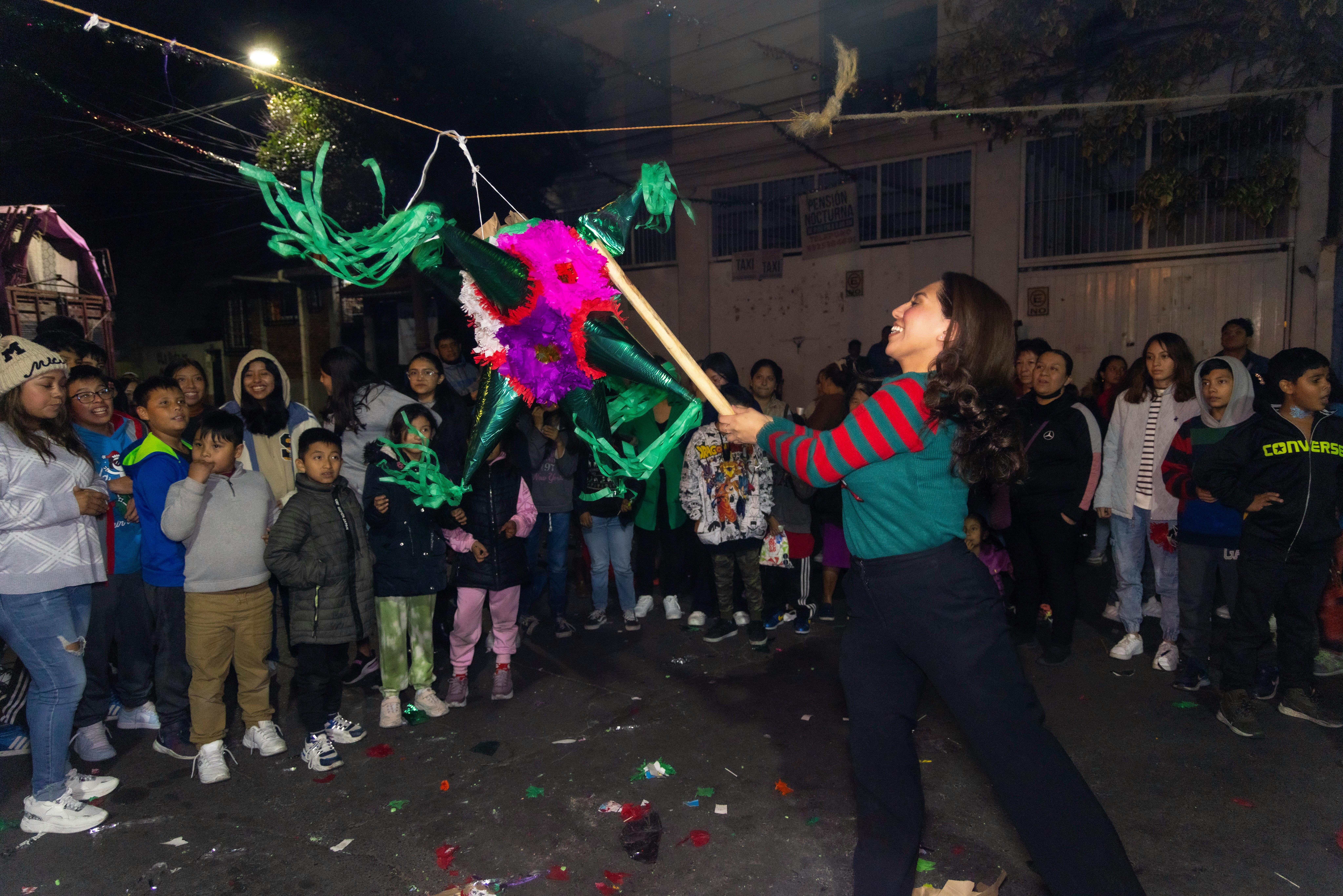 People Watching a Woman Hit a Pinata with a Stick · Free Stock Photo