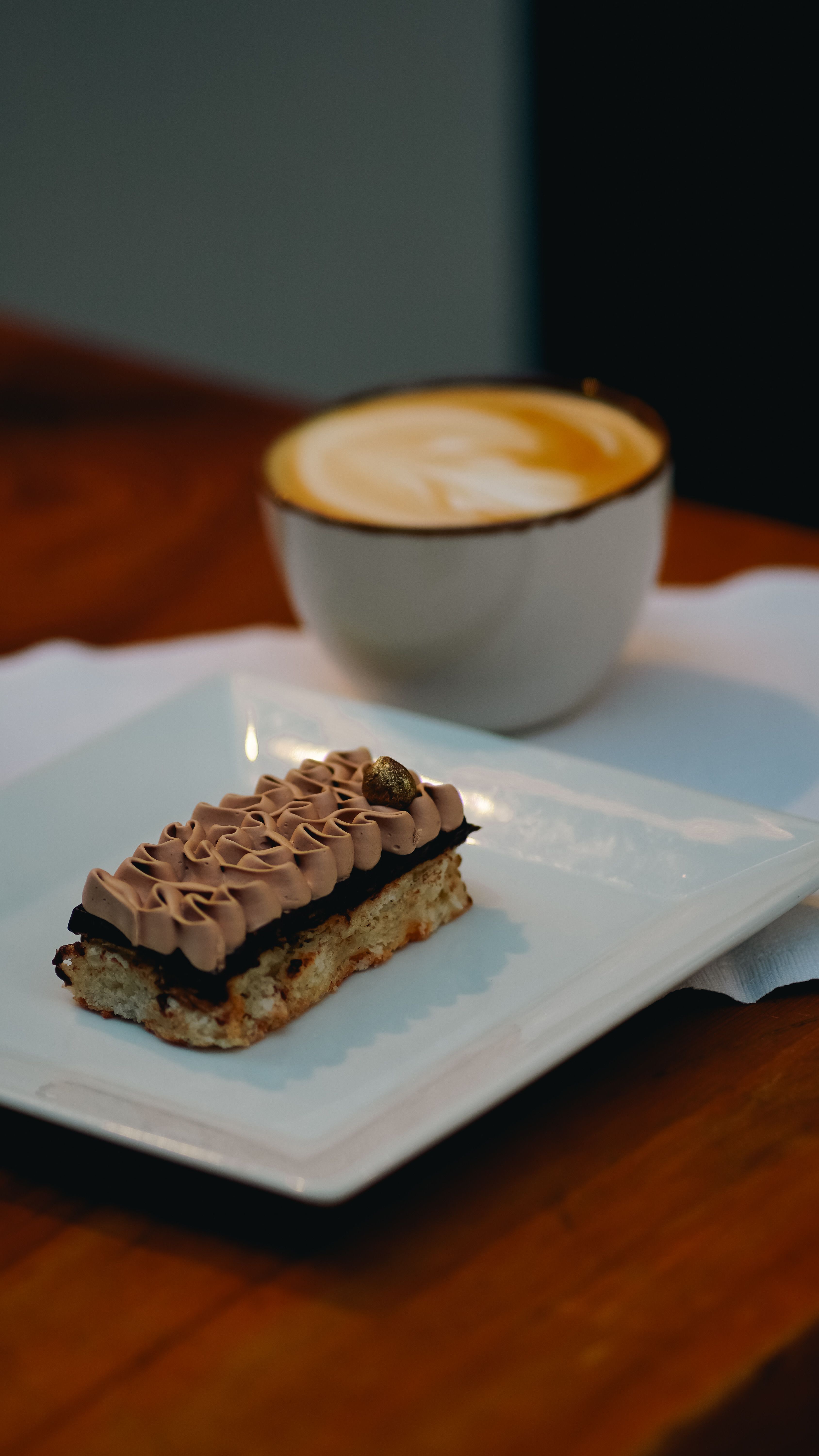 Pastry with Cream on Top beside Cup of Cappuccino · Free Stock Photo