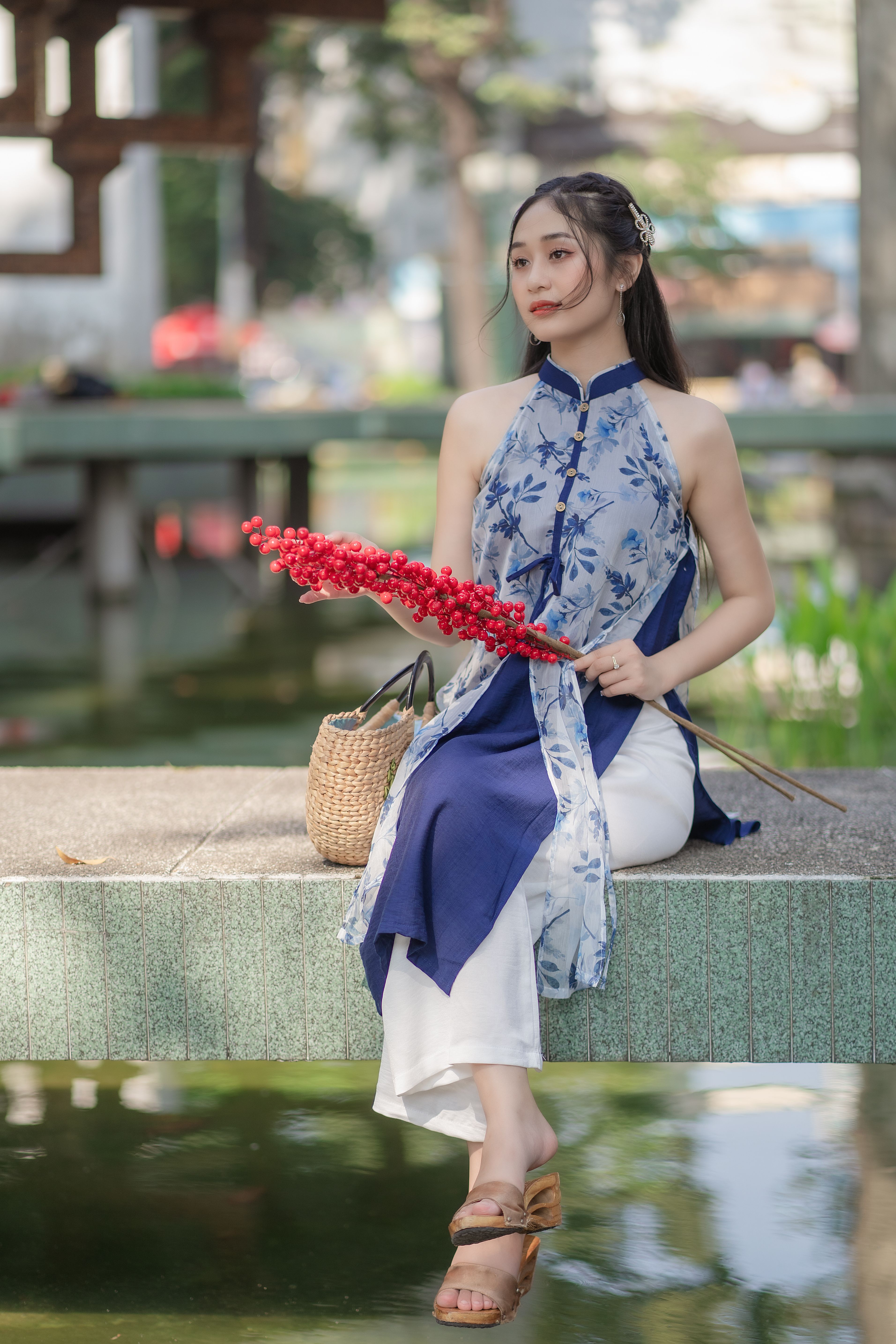 Model in Traditional Vietnamese Floral Tunic and White Pants Sitting on ...