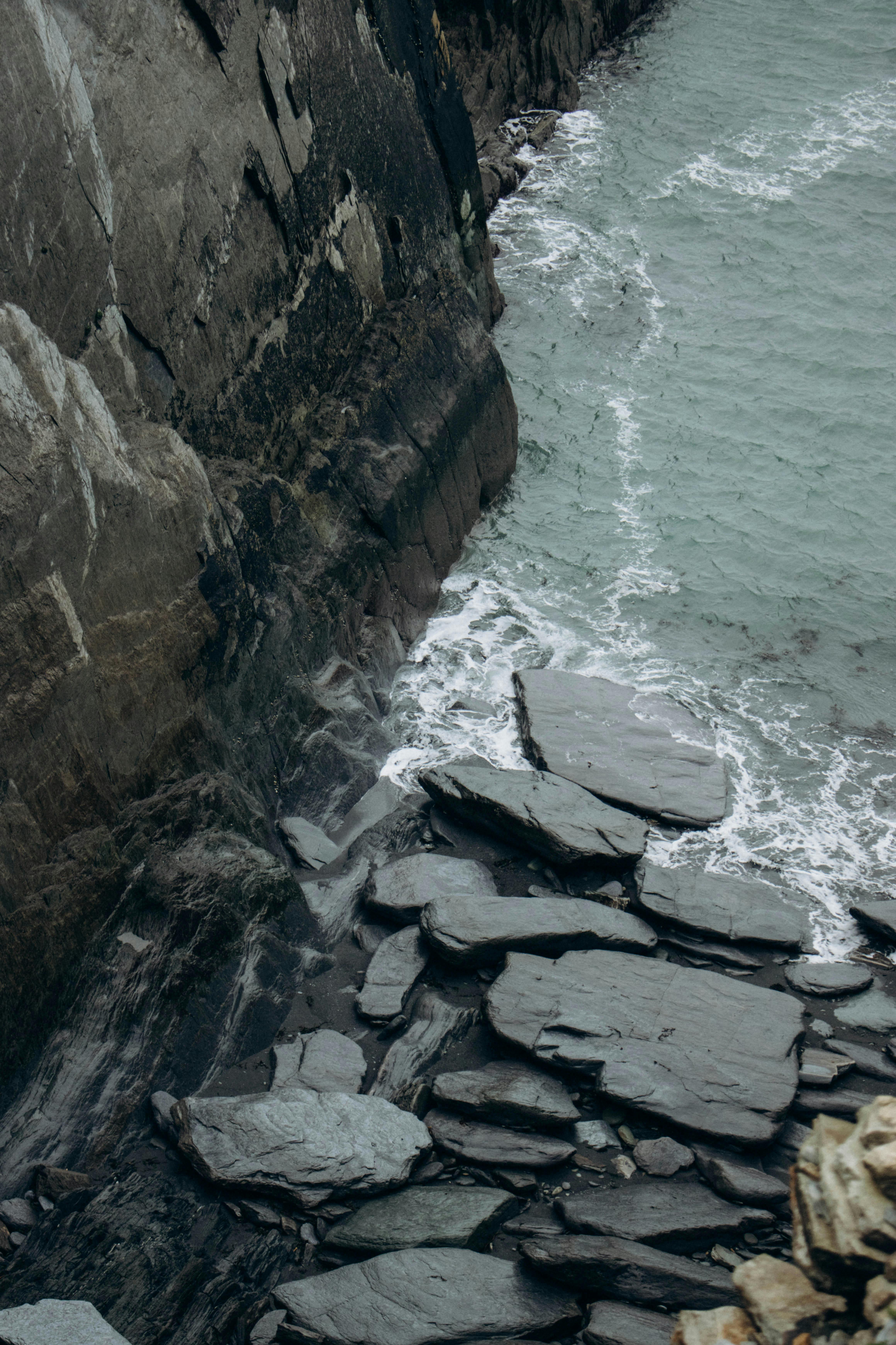 Flat Rocks under Rocky Cliff · Free Stock Photo