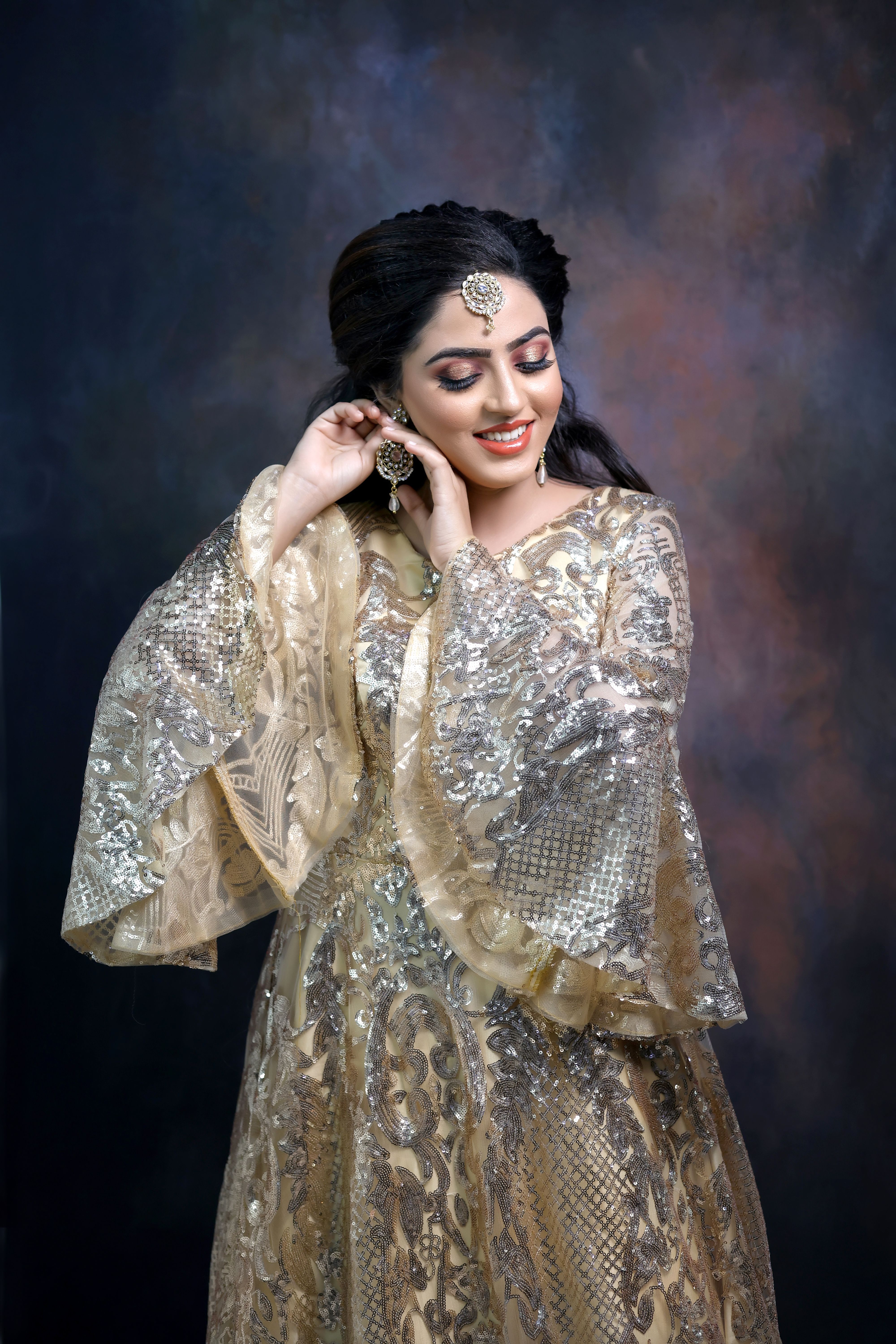 Model in Glistening Dress Wearing Traditional Jewelry · Free Stock Photo